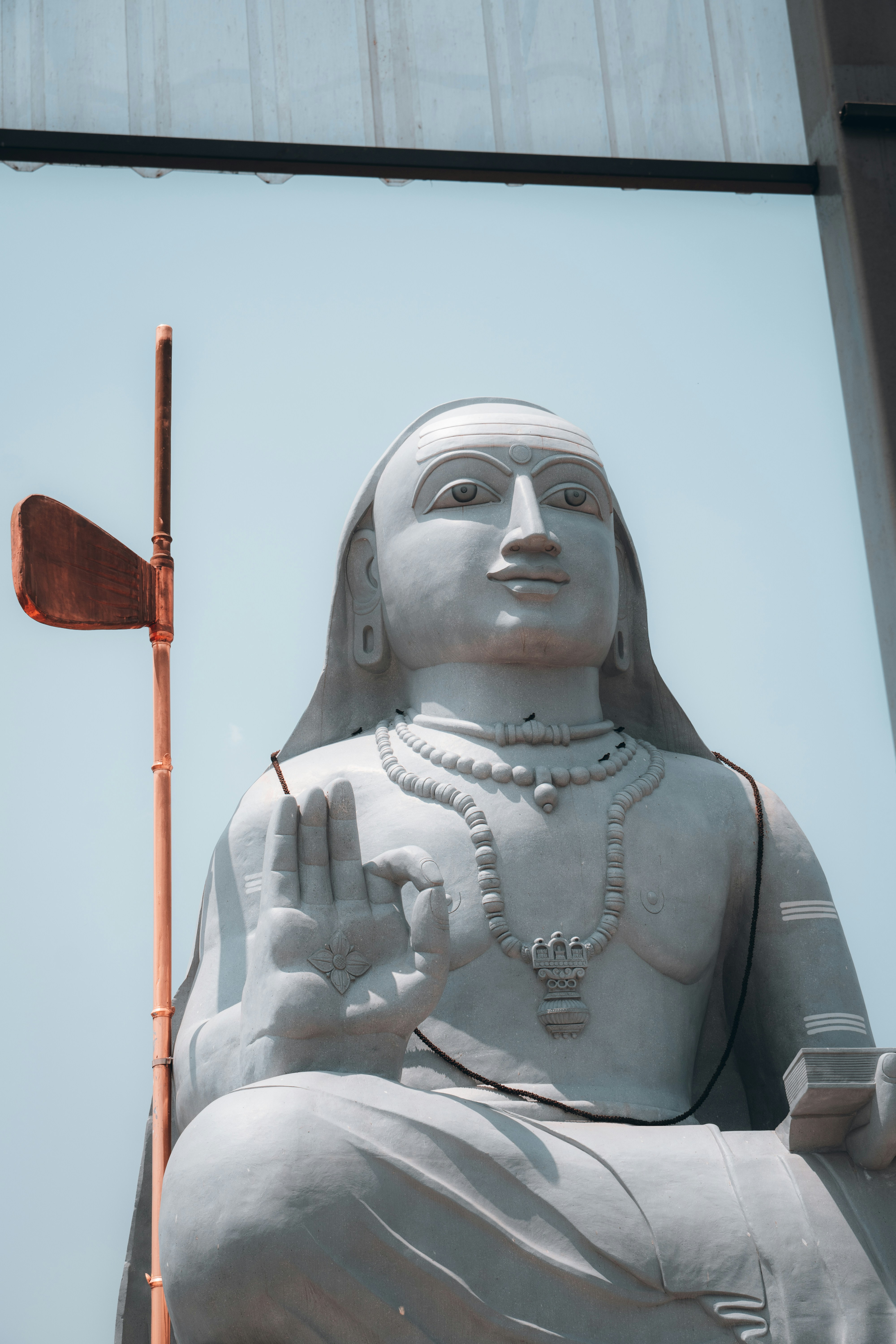 Meditative Guardian: Stone Avatar Behind a Pale Sky