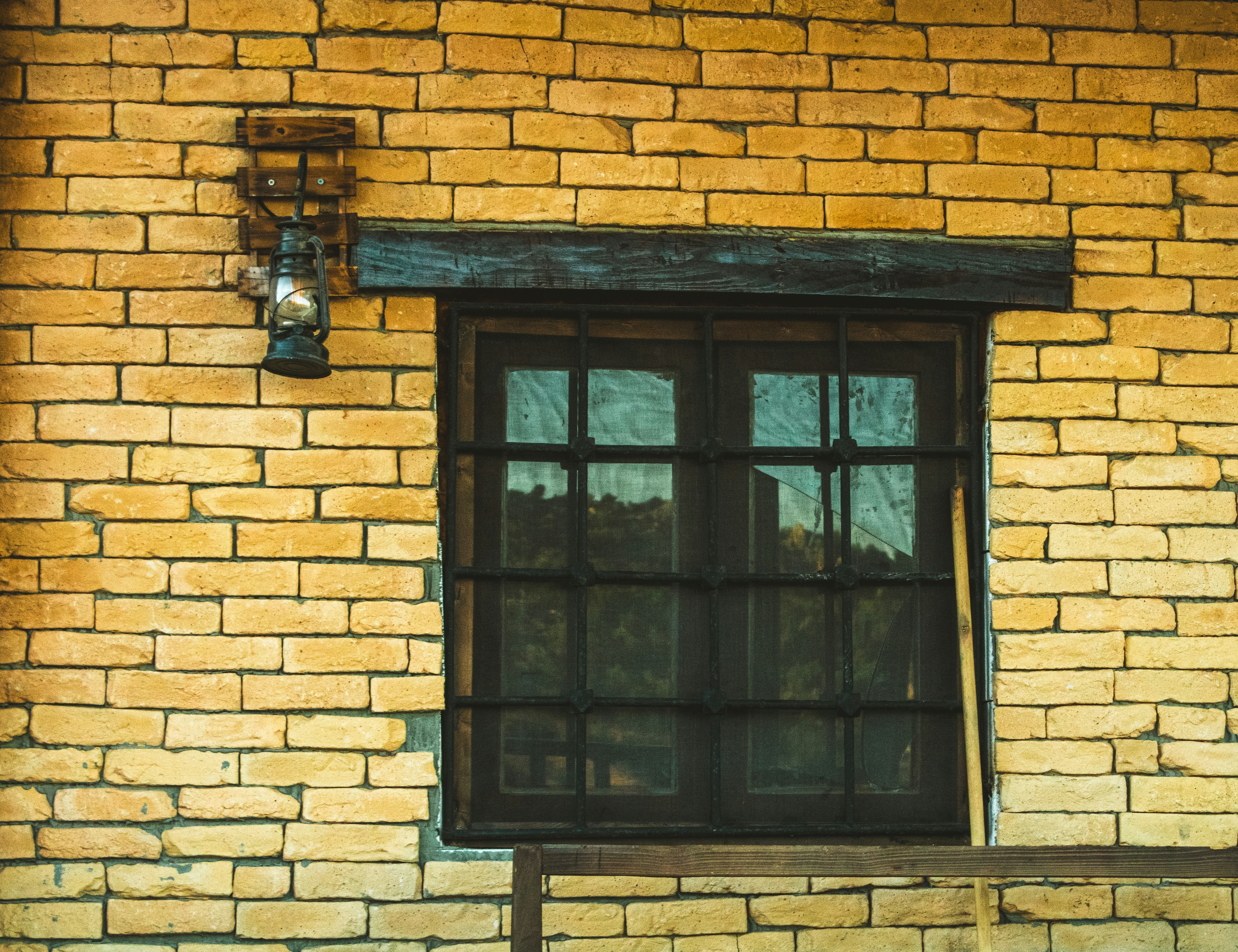 A Weathered Window in a Sunlit Brick Facade