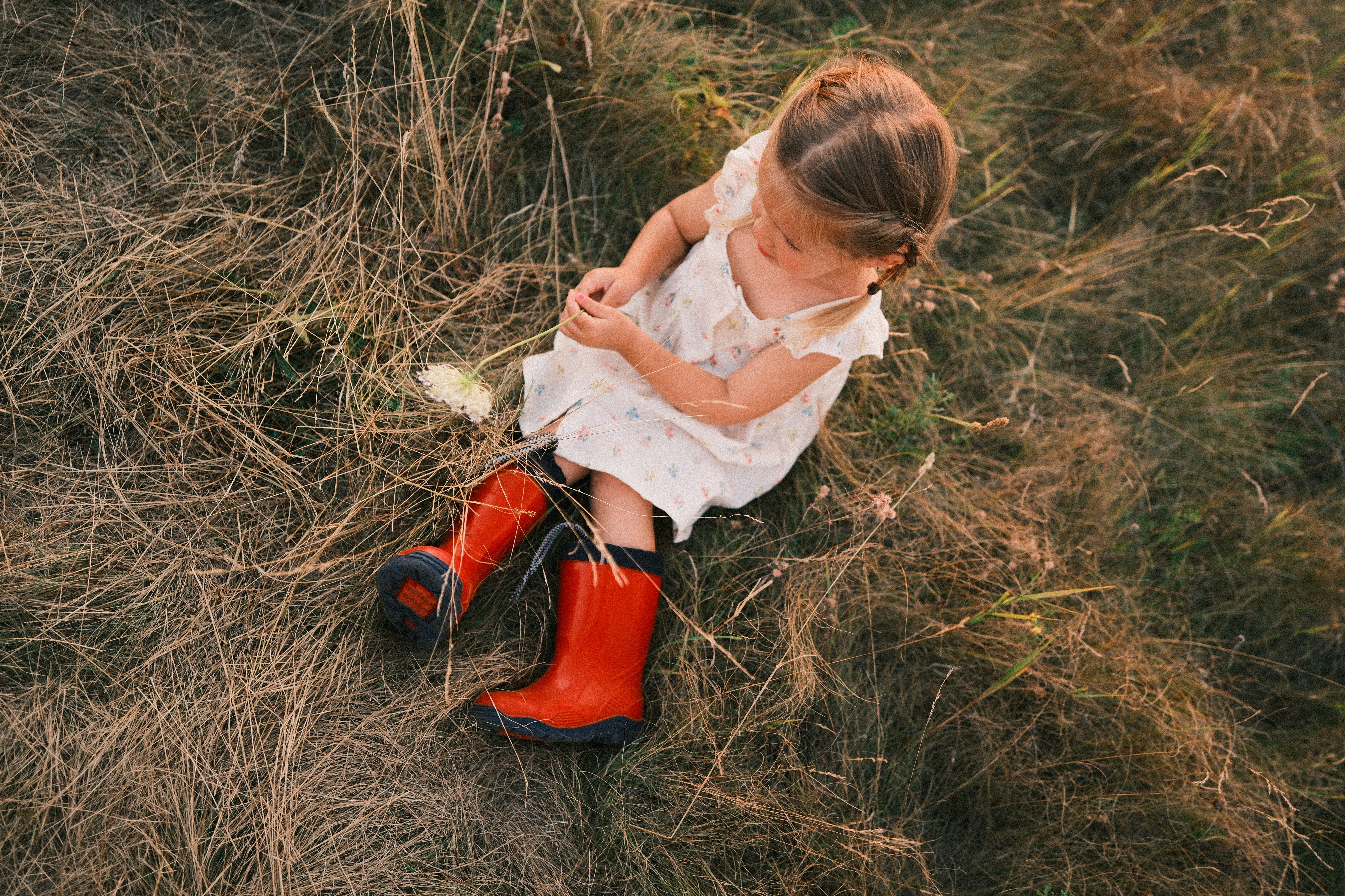 Red Boots in the Grass: A Quiet Moment of a Young Girl