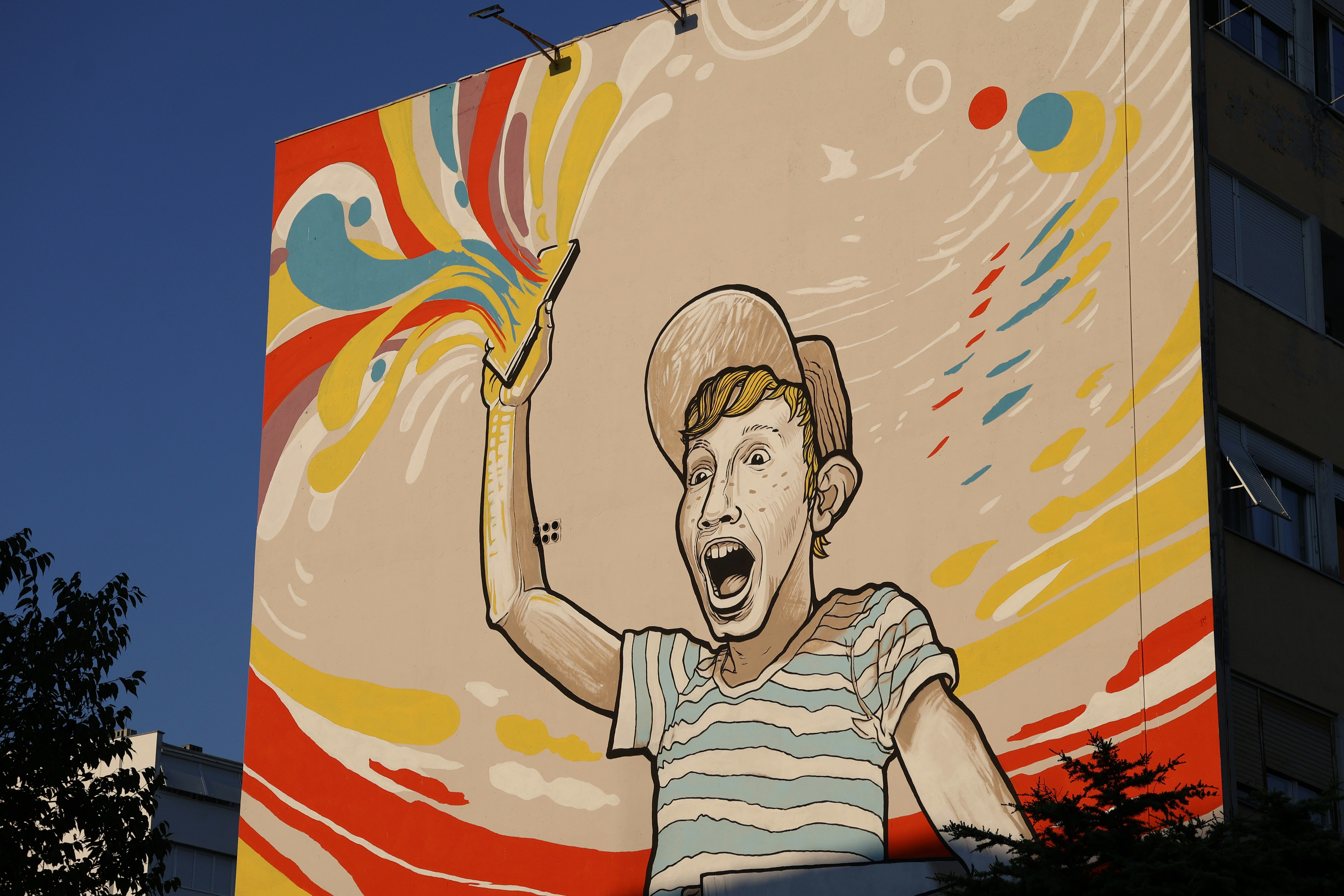 Splash of Color: muralist raises a yell across a sunlit facade