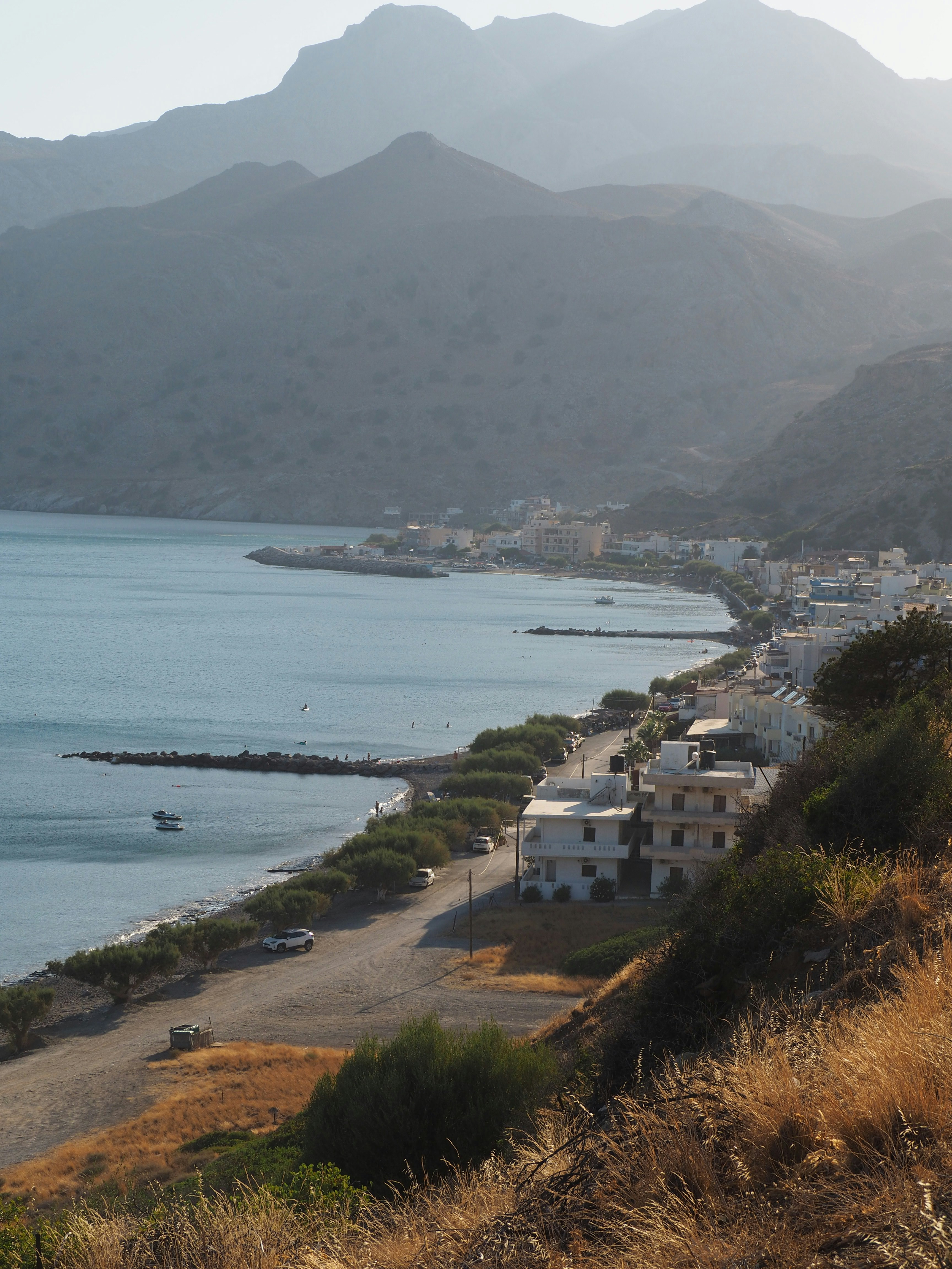 Coastal Village Snaking Along the Sea Under Looming Mountains