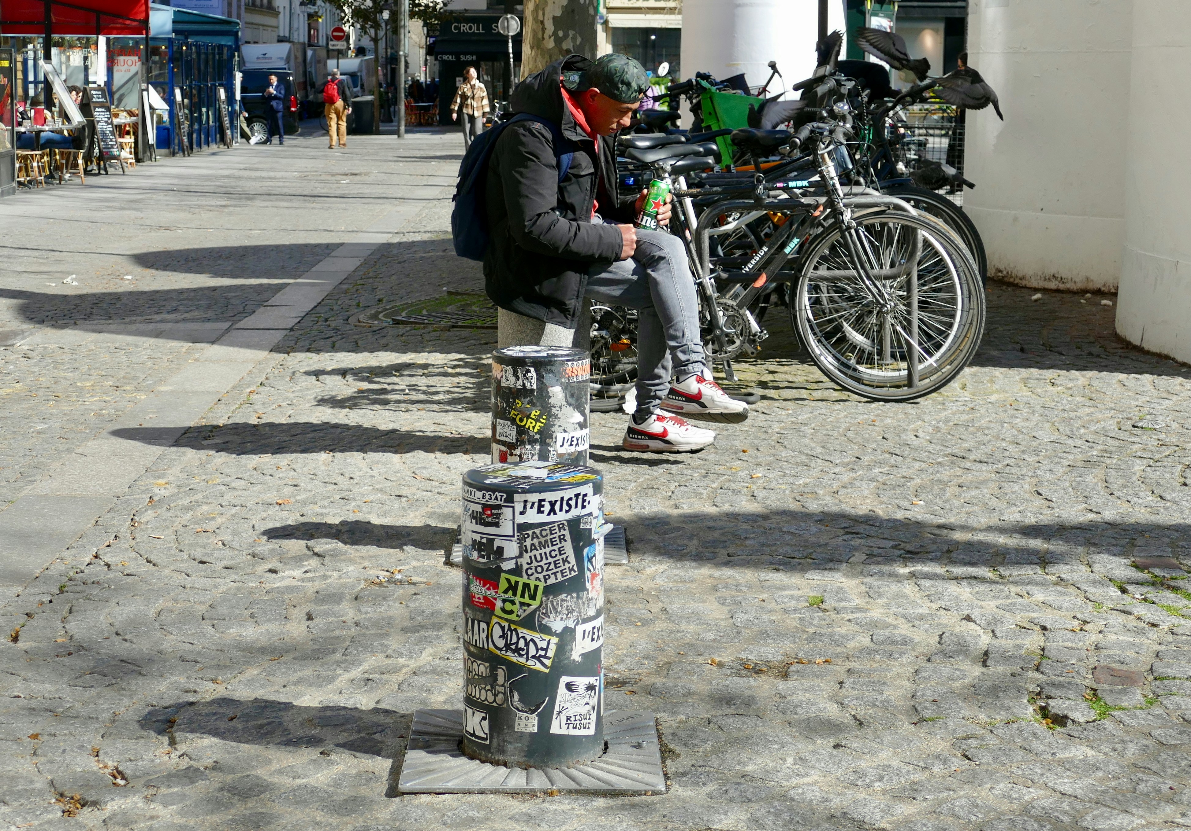 Street perch: a lone rider rests on a graffiti-stamped post