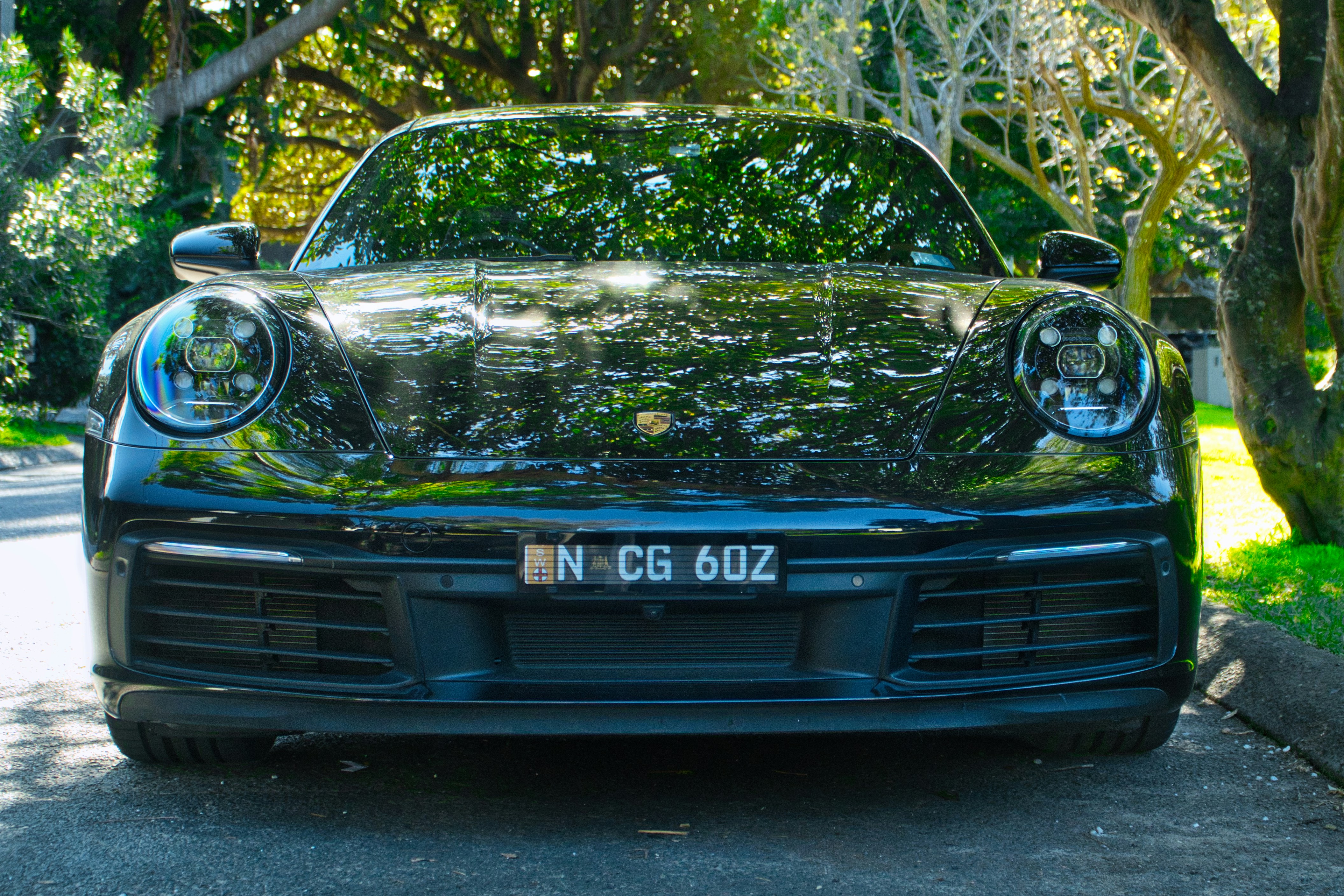 Front-Facing Porsche Under the Shade: Chrome Reflections and Glossy Hood