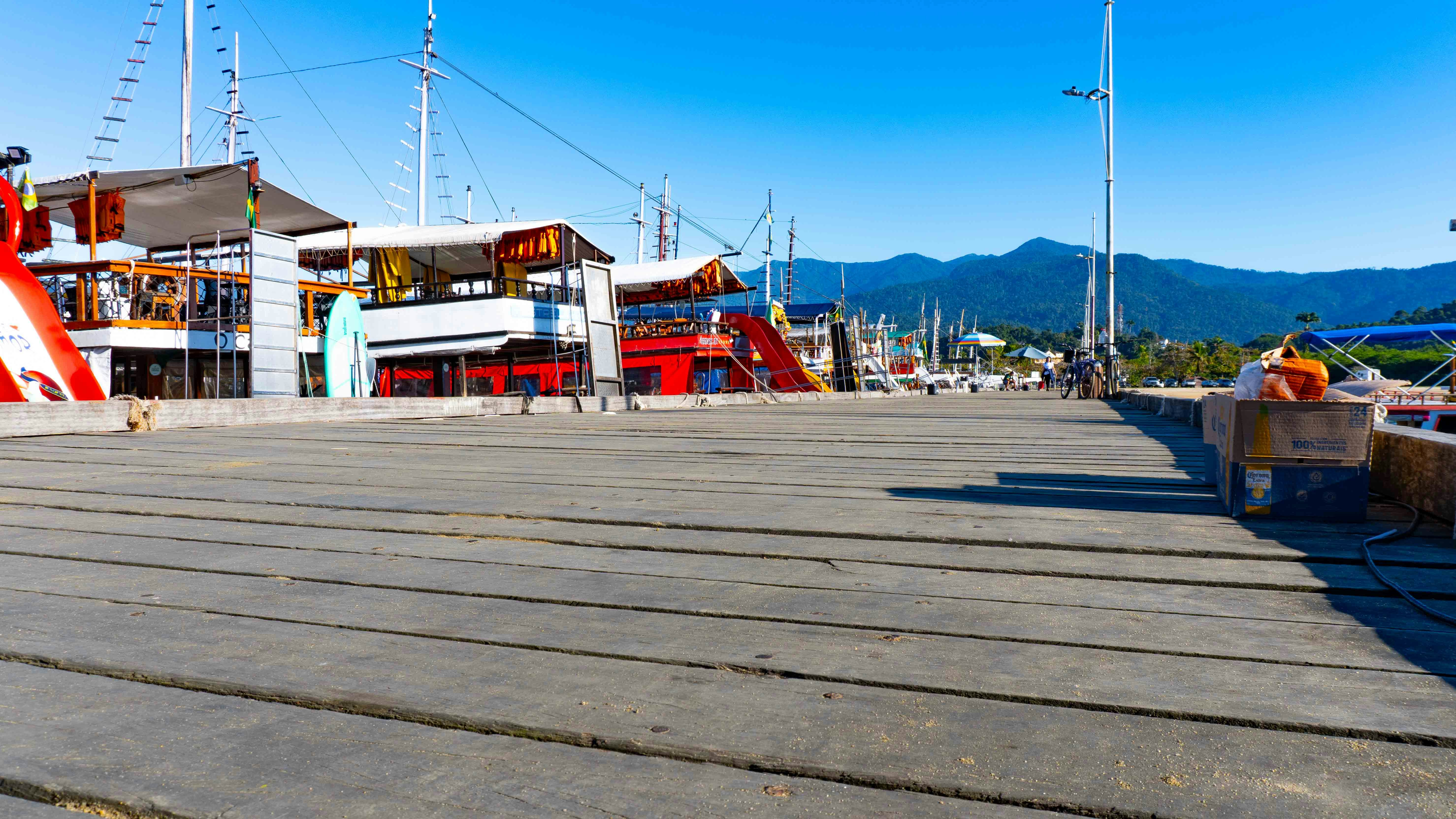 Harbor Pier Prelude: Boats, Wood, and a Bright Blue Sky