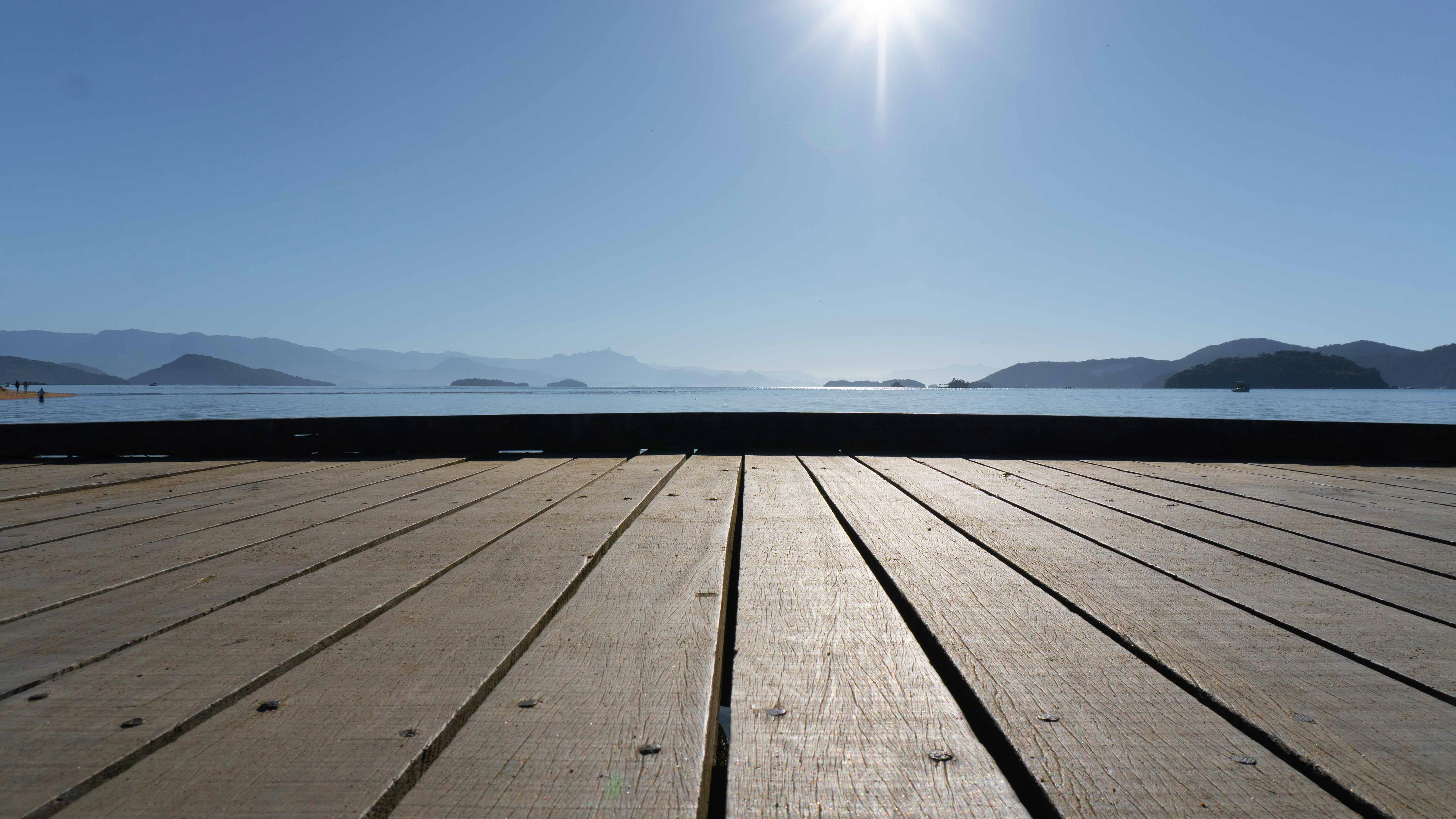 Sunlit Pierboard: A Quiet Horizon Over Wooden Planks