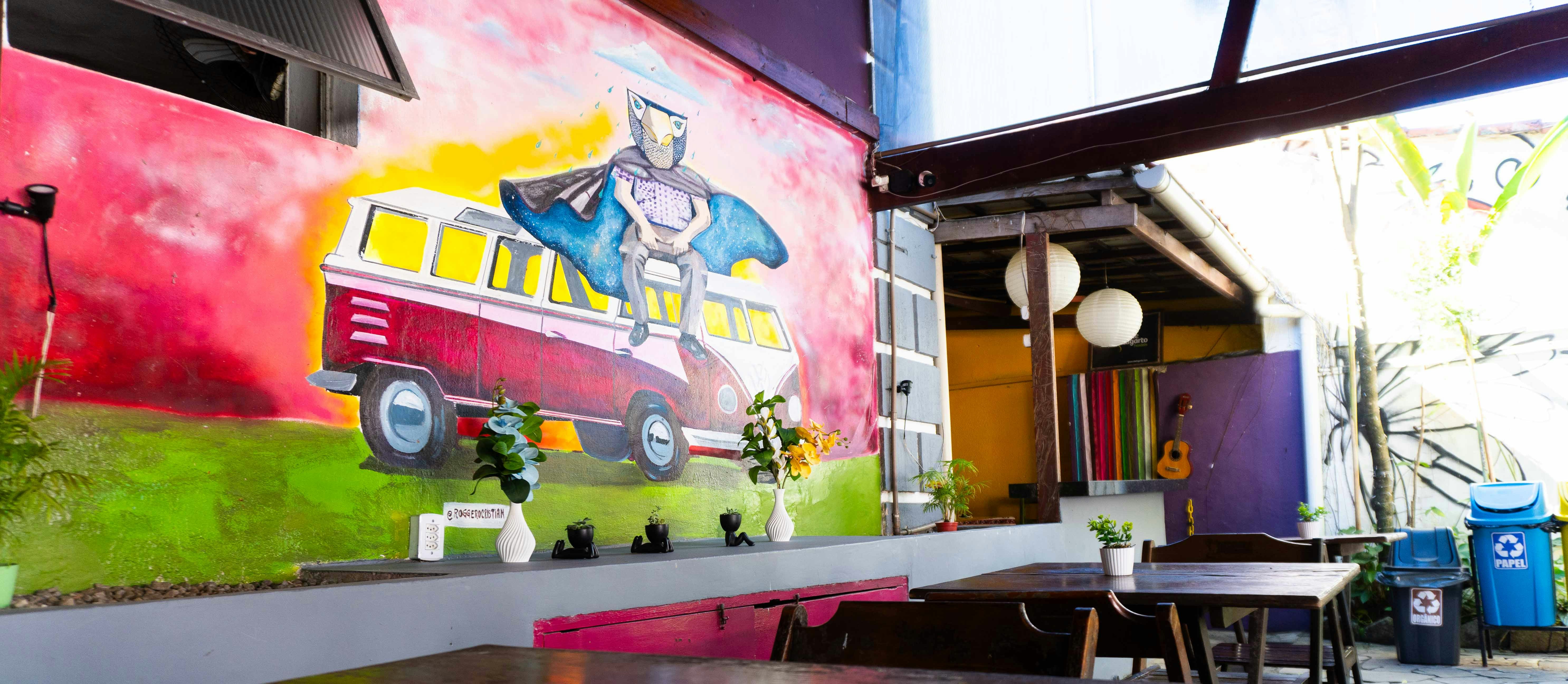 Vibrant mural cafe with quirky retro bus artwork and shaded courtyard