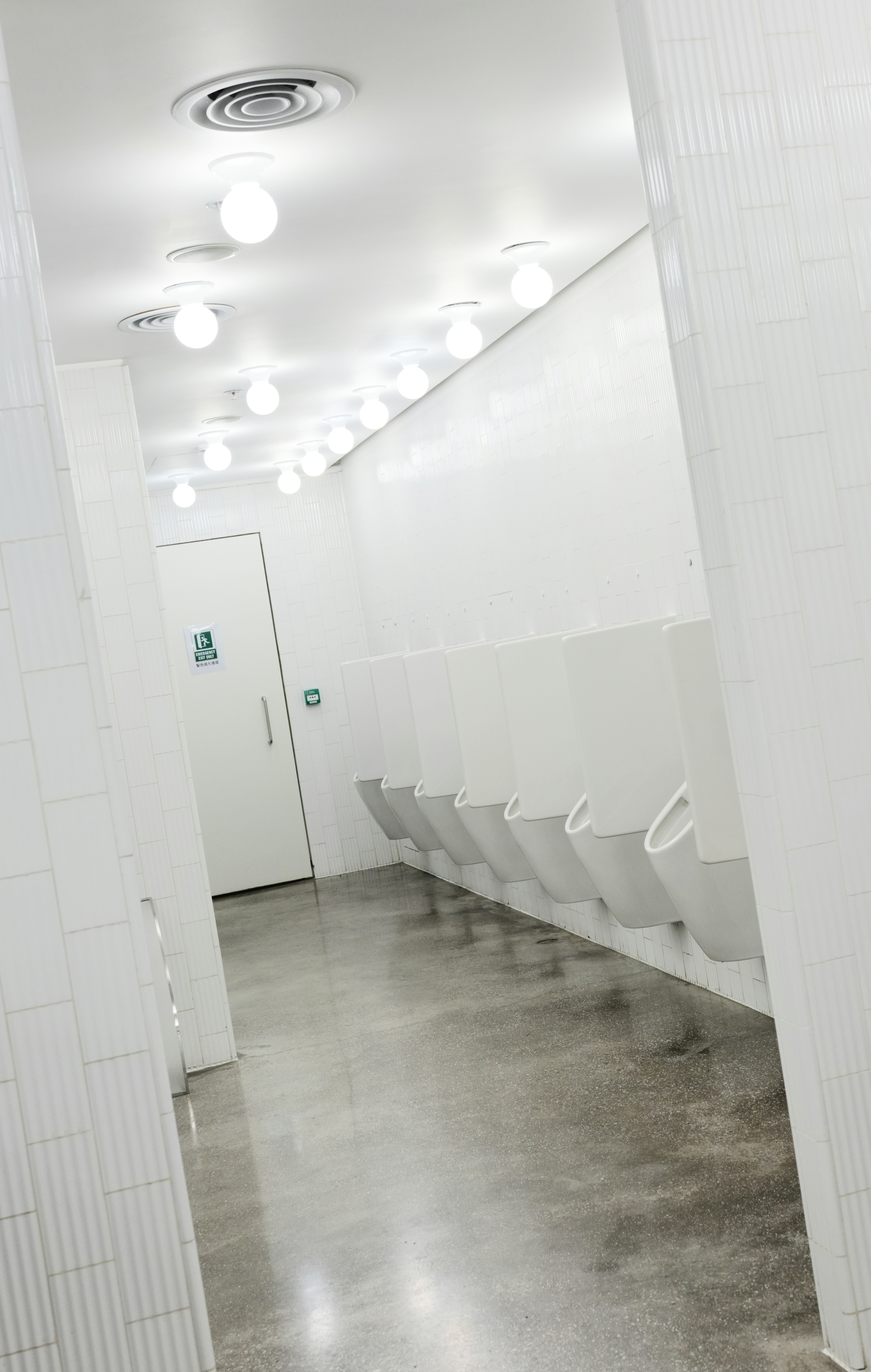 Sterile Line: Row of Urinals in a Bright Corridor
