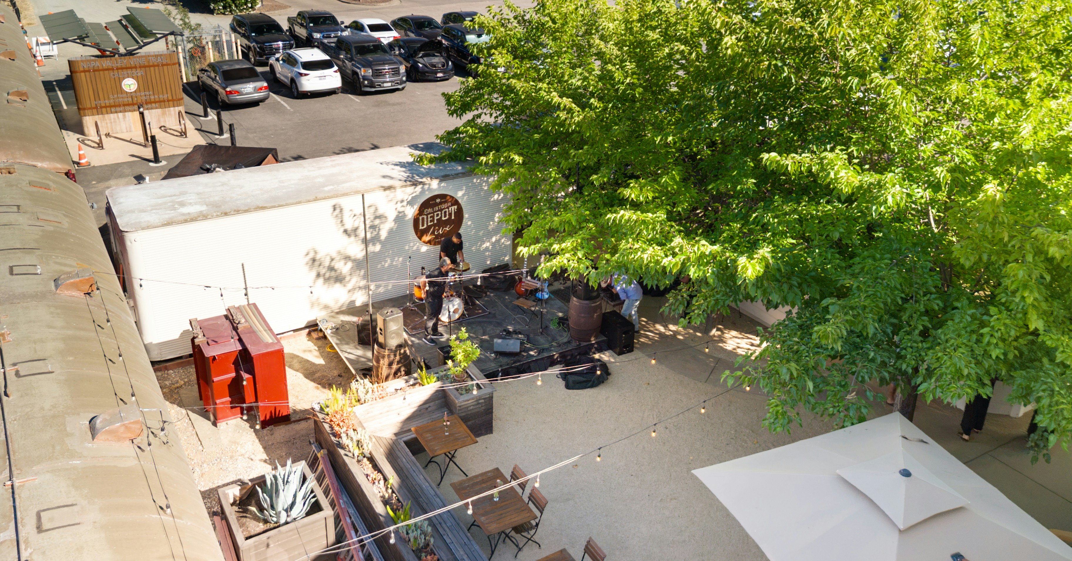 Rooftop Setup: Street-level Music and Gathering under Dappled Shade