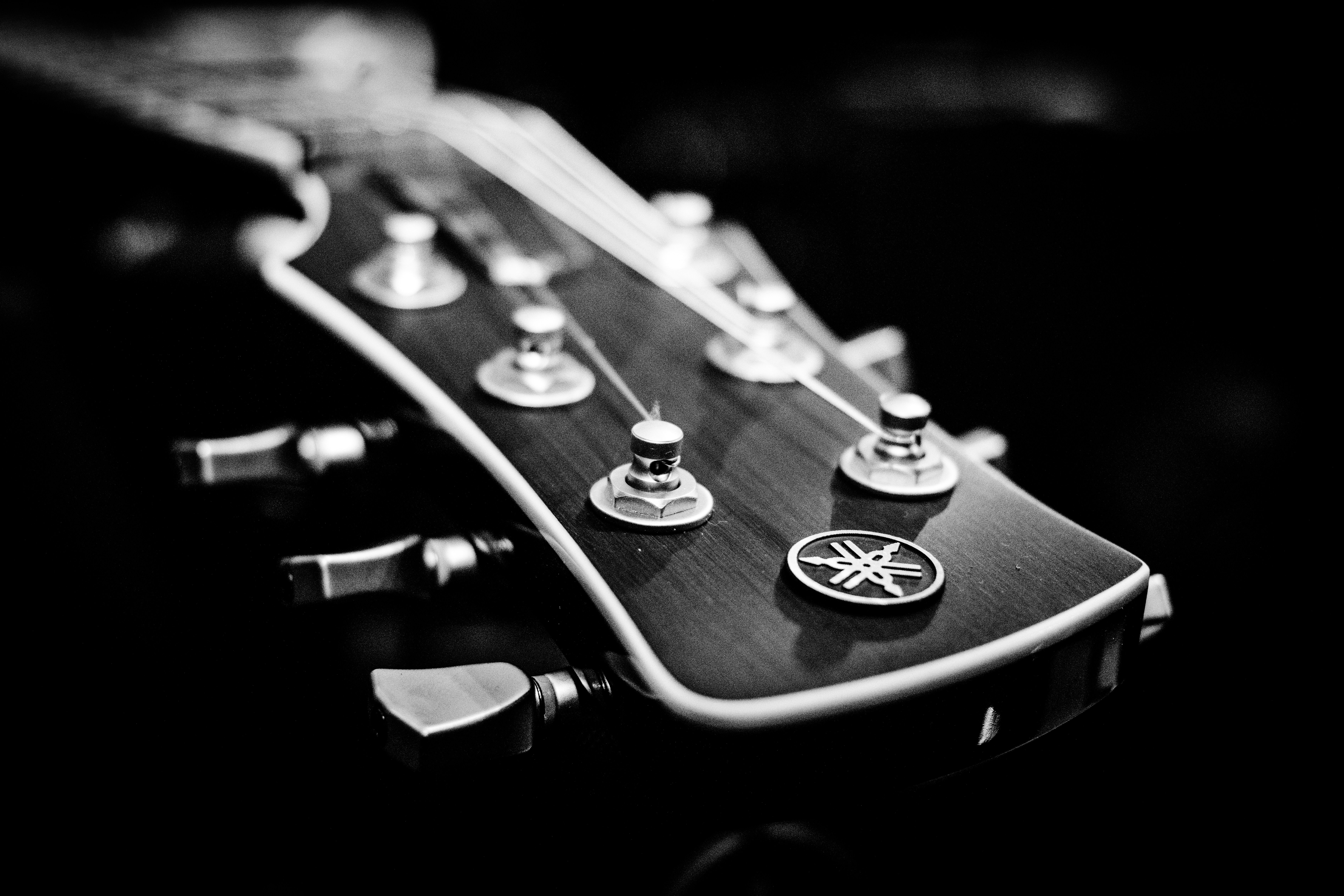 Close-up of a Yamaha guitar headstock in monochrome, highlighting tuning pegs and logo