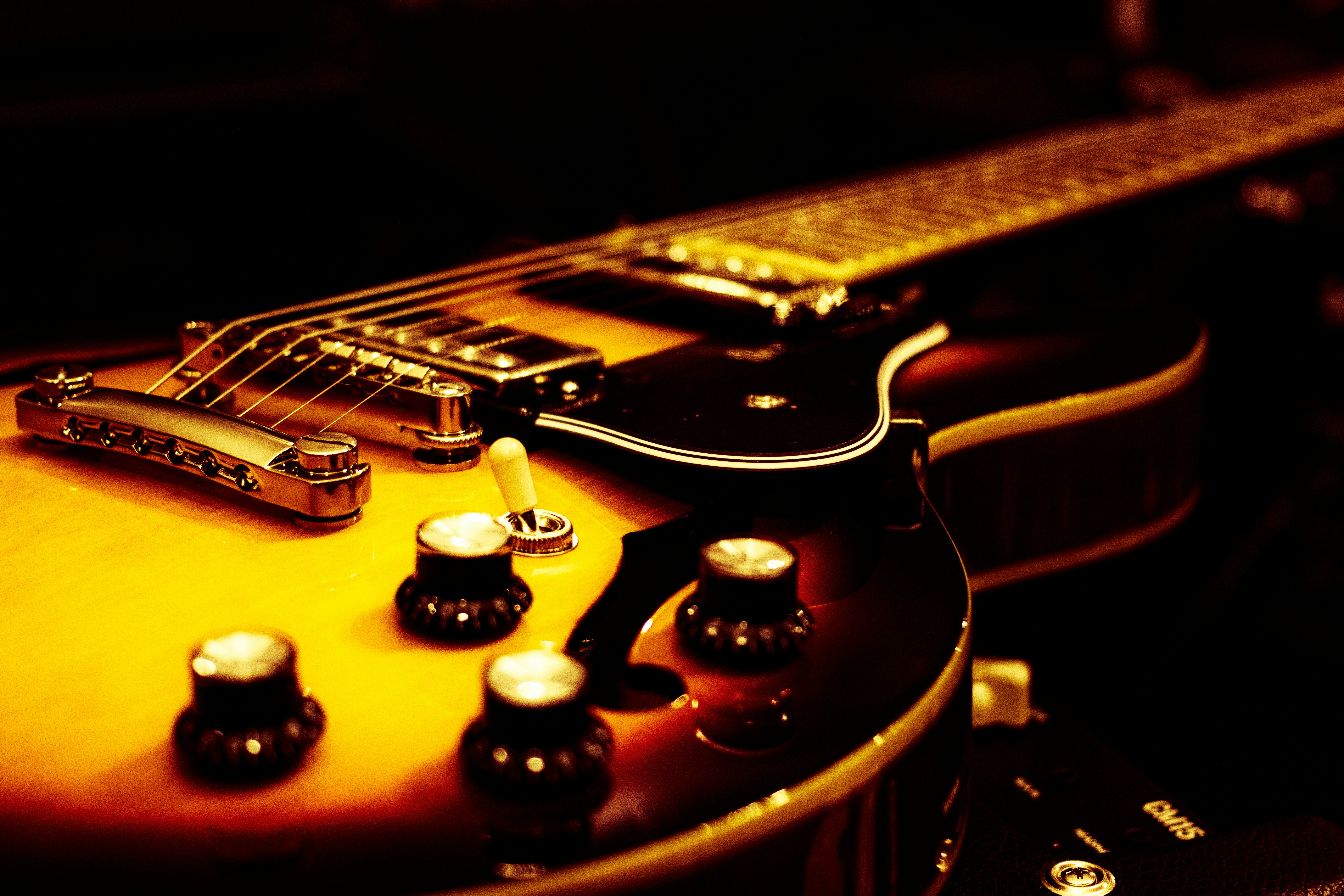 Ambered Strings: Close-Up of a Sunlit Electric Guitar