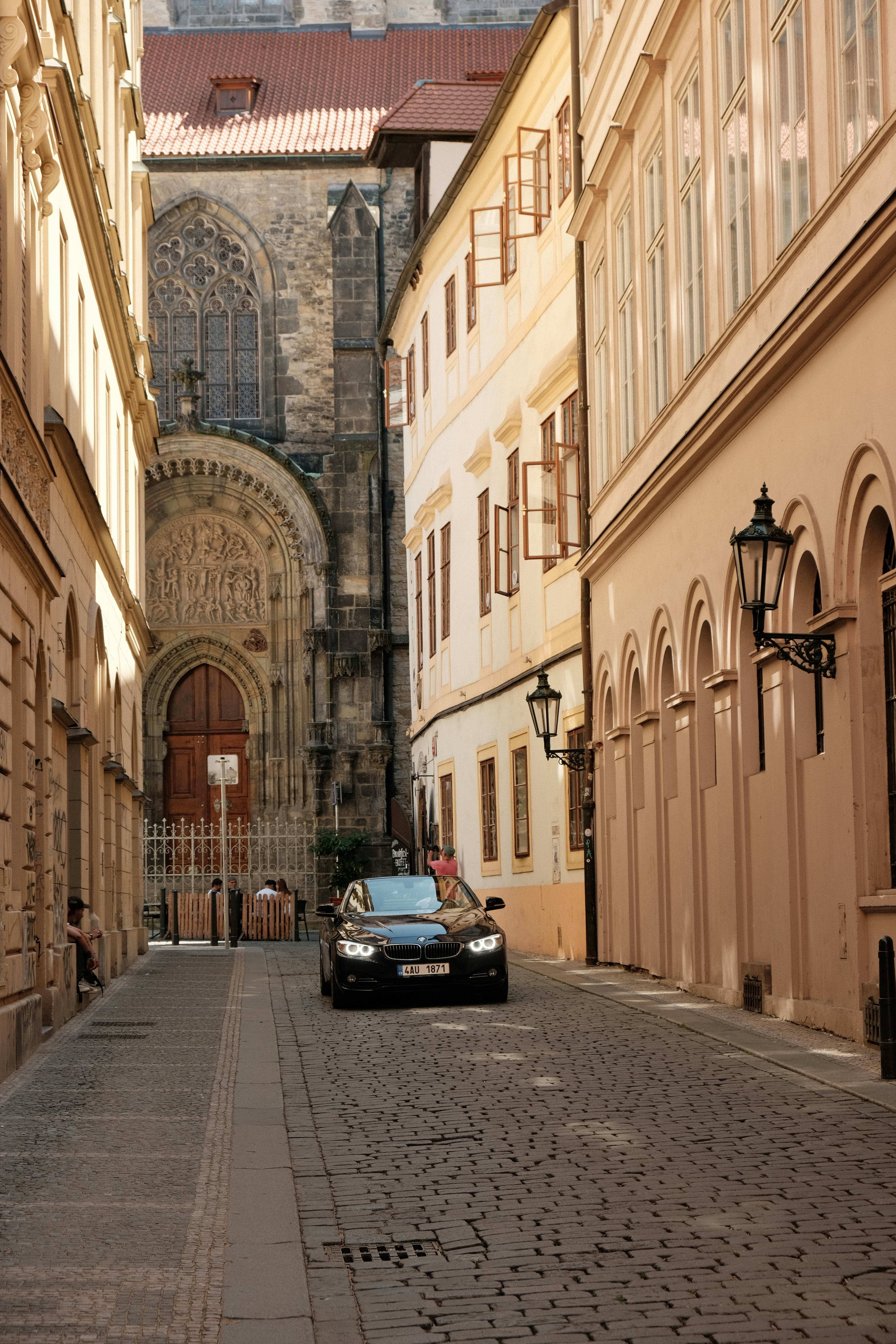 Car on a Historic Street: Cathedral Gate Framed by Lighted Facades