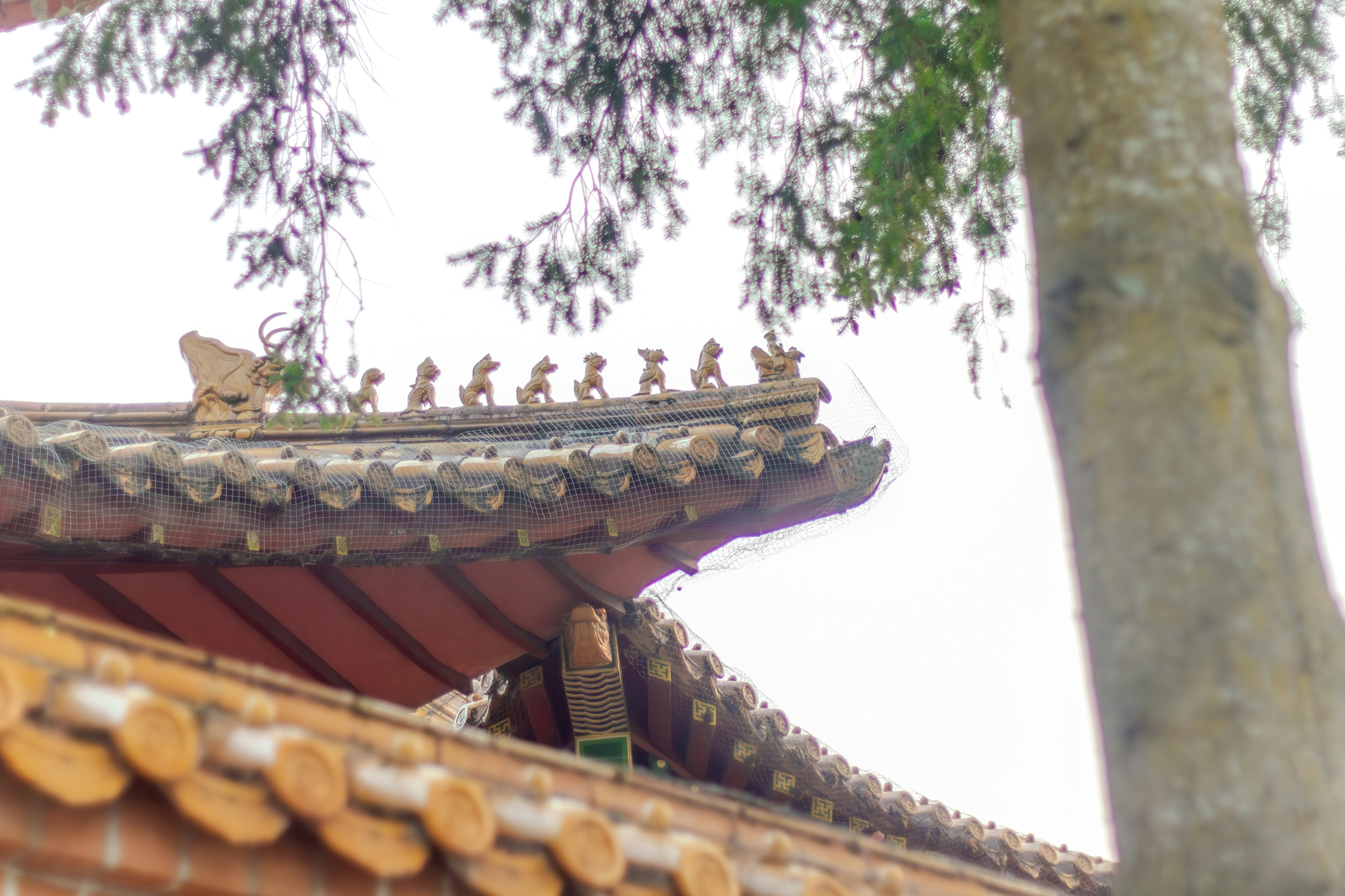 Row of Roof Guardians: Tiny Sculptures Crowning a Traditional Eaves