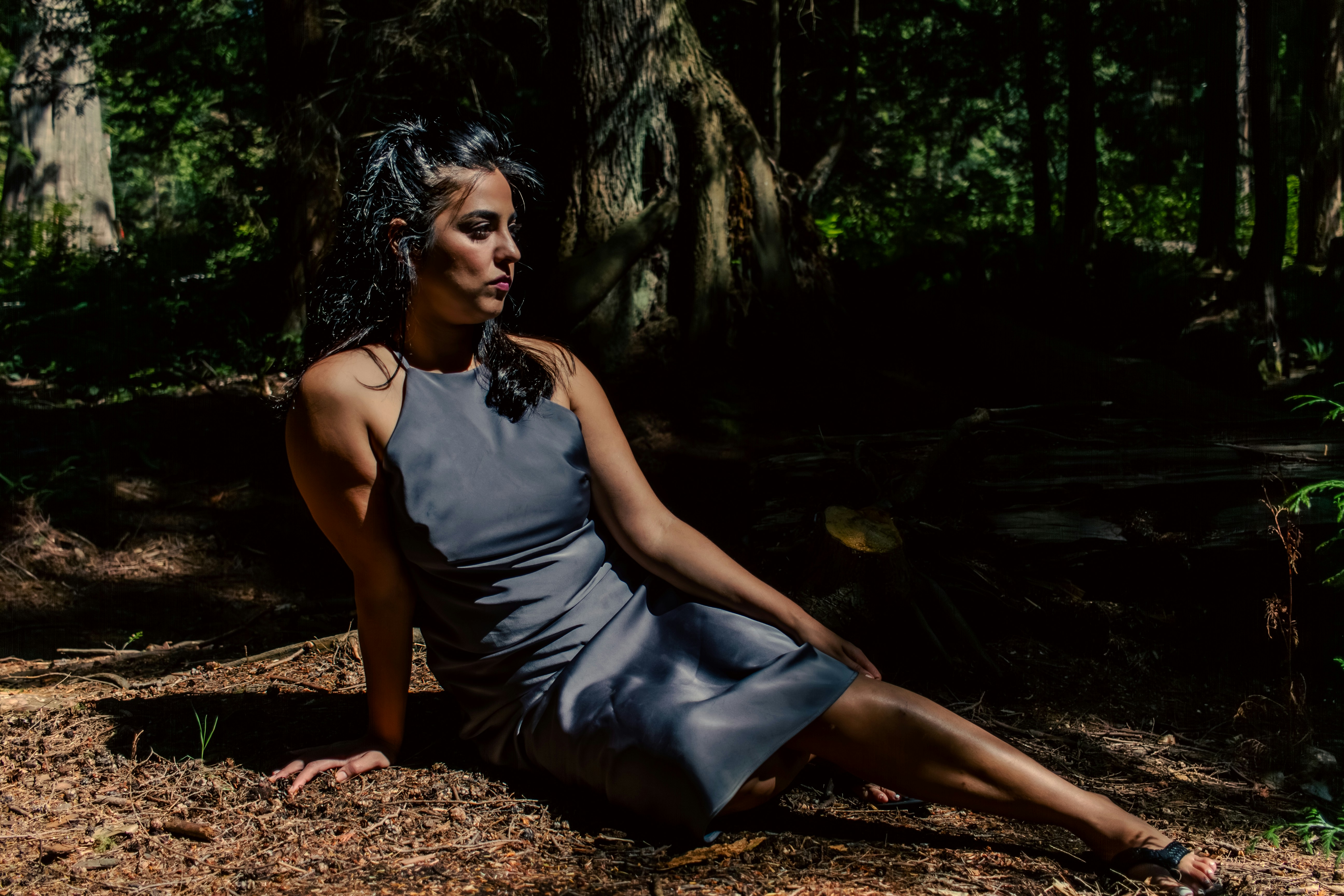 Shadowed Grace: A Woman Reclines in a Forest Clearing