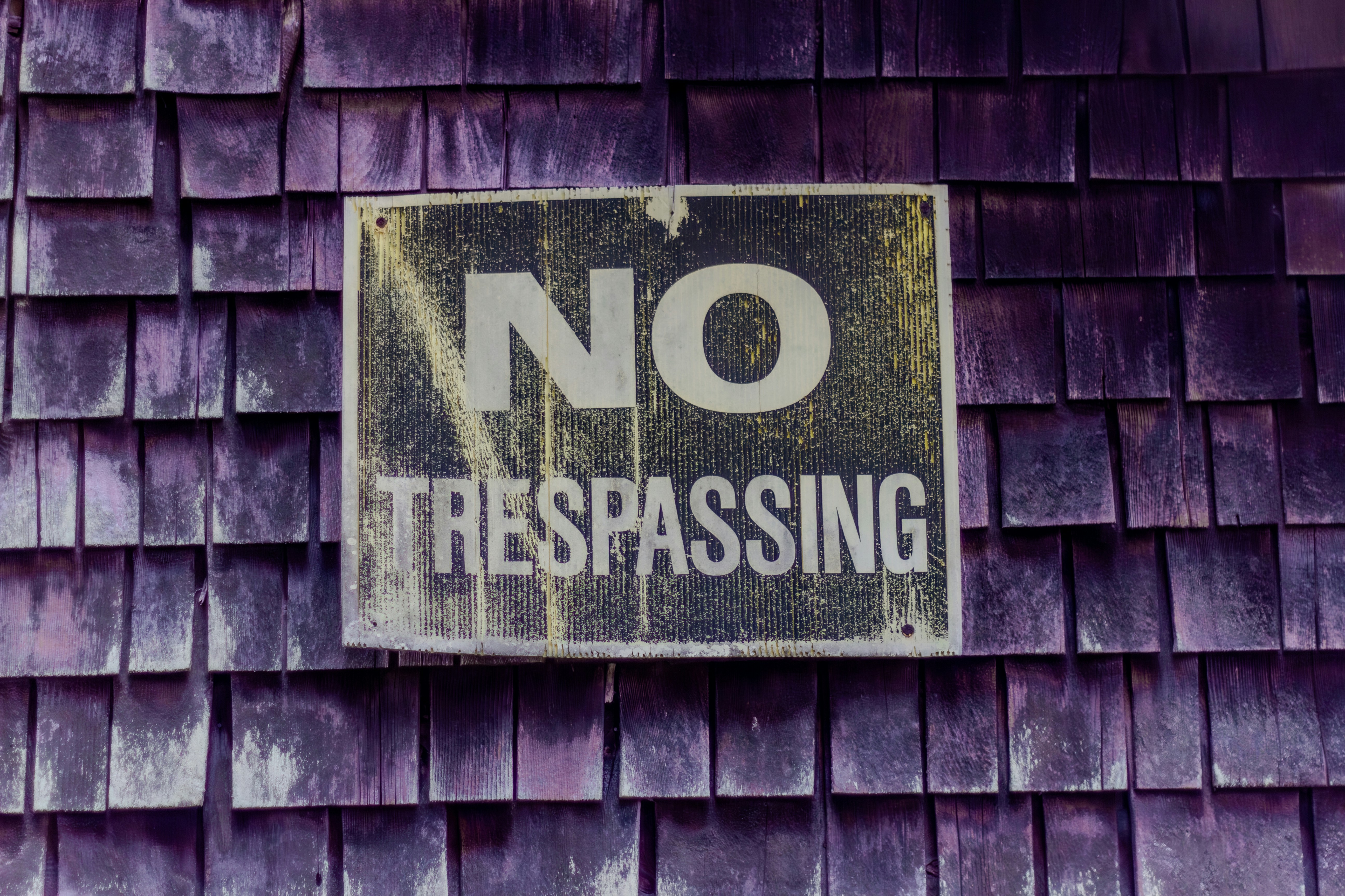 No Trespassing: Weathered Sign on Shingled Wall