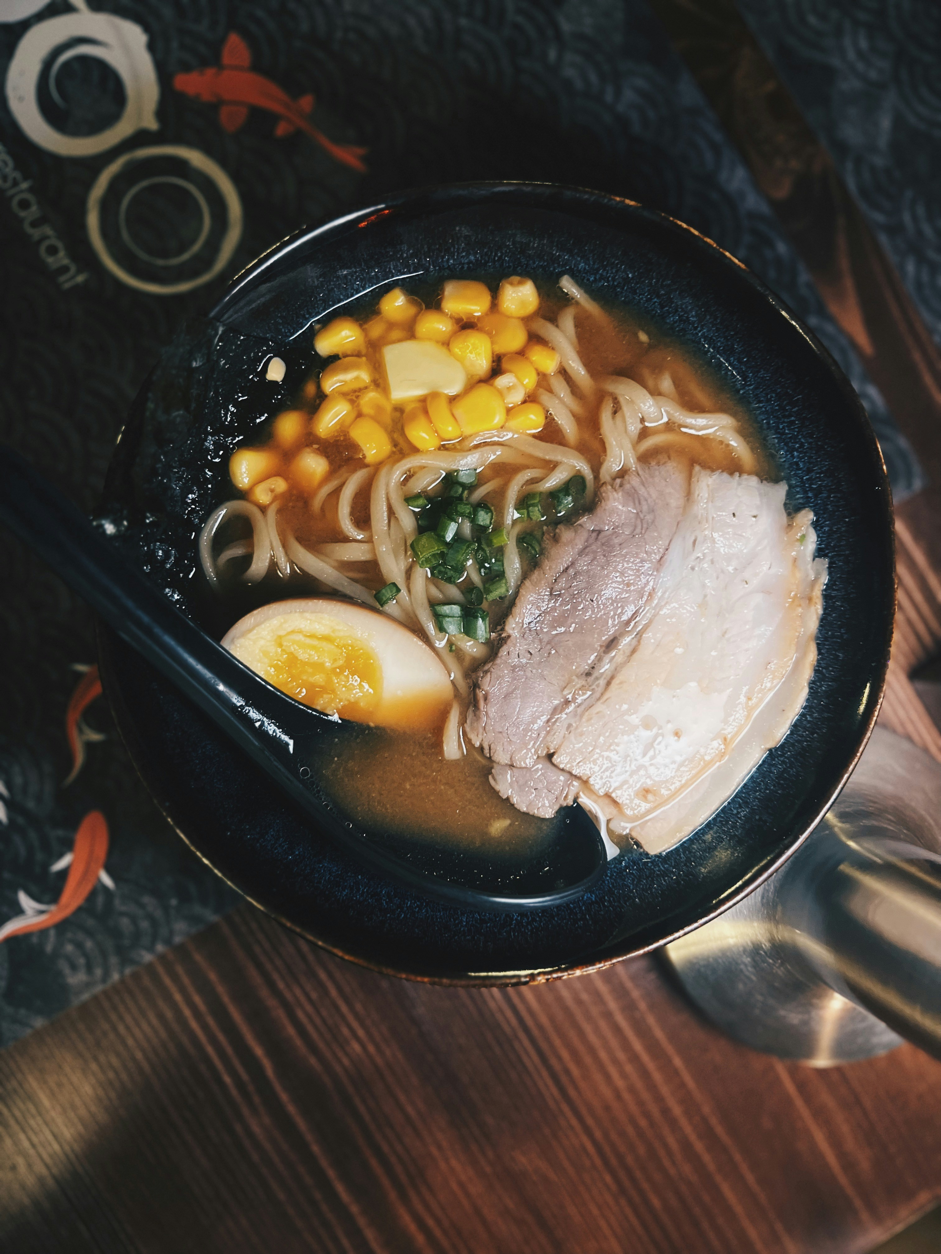 Slab of pork and pearls: a bowl of ramen under warm kitchen lights