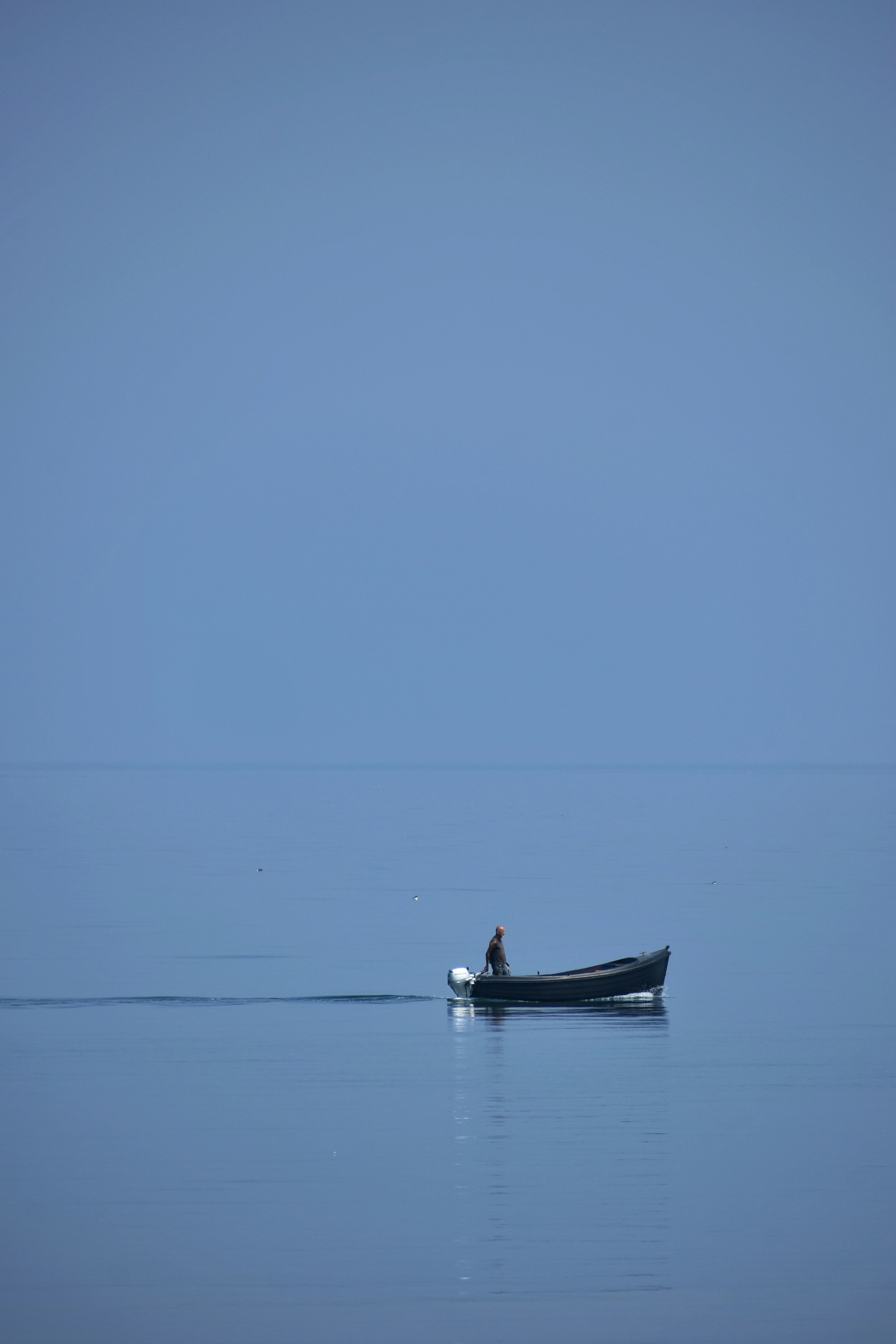 A solitary boat on a vast blue plane