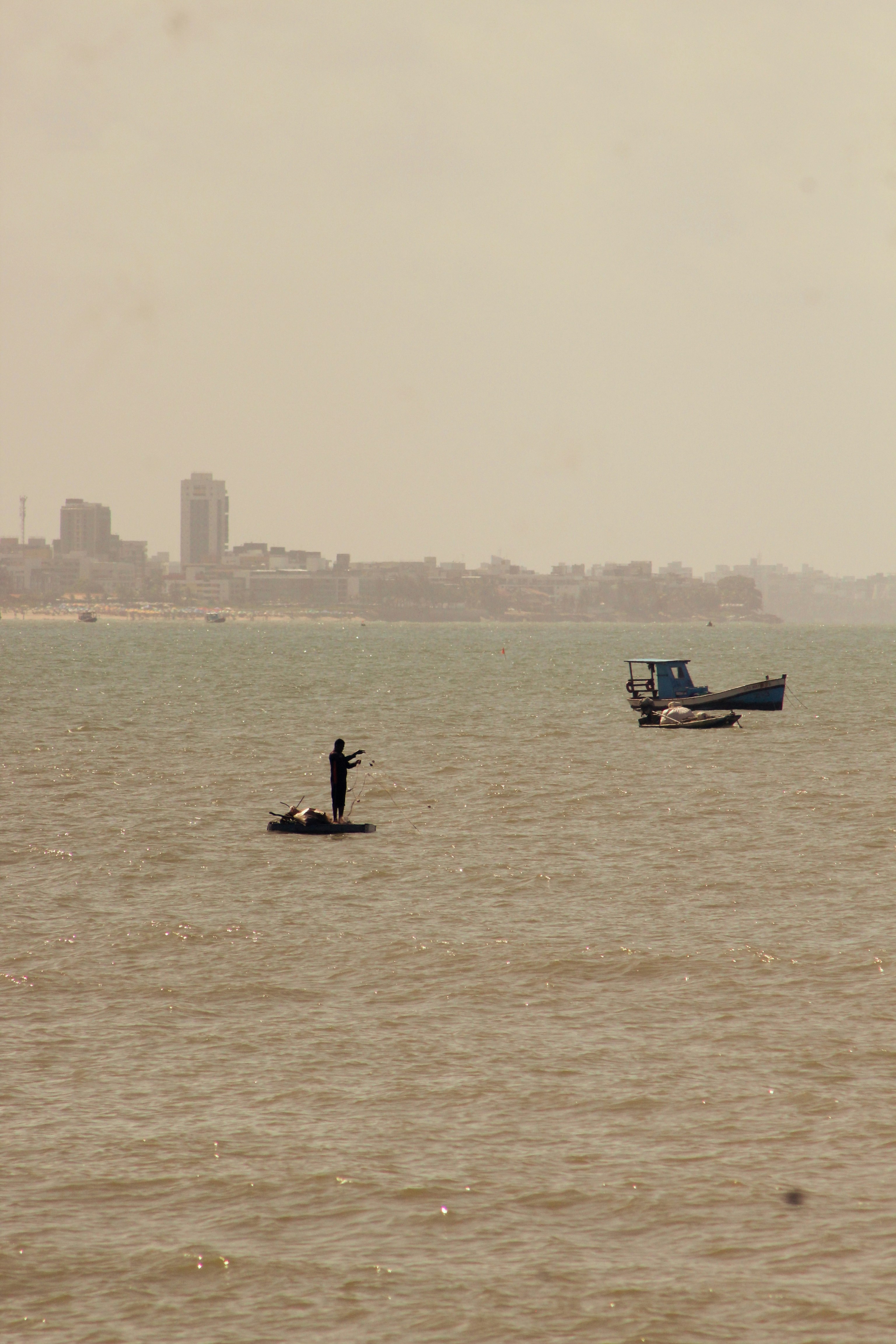 Silhouette on the Horizon: A Lone Paddle on Quiet Seas