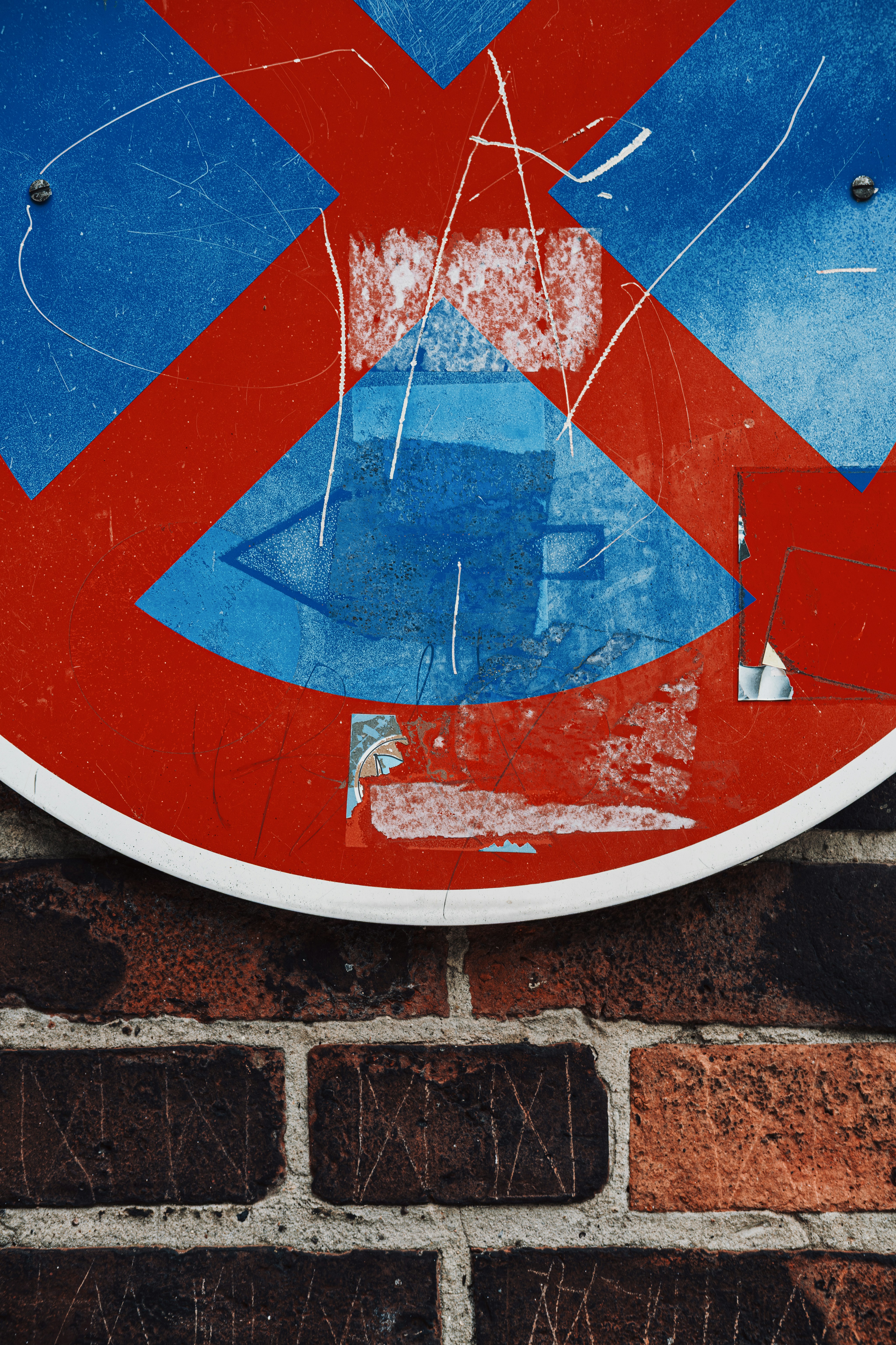 Urban Abstract: Weathered No Parking Sign Over Brick Facade