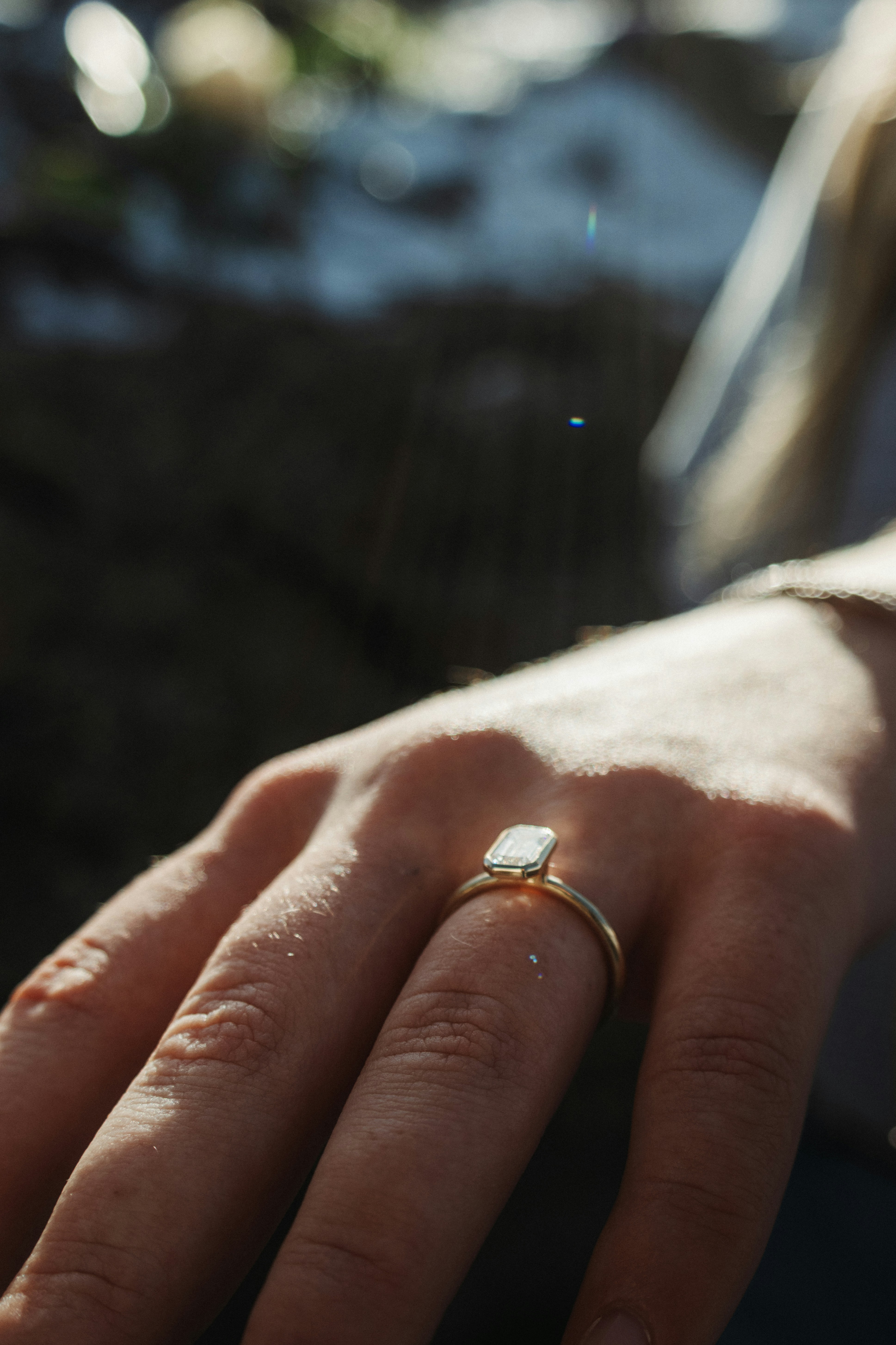 A Quiet Glint: Diamond Ring on Sunlit Finger