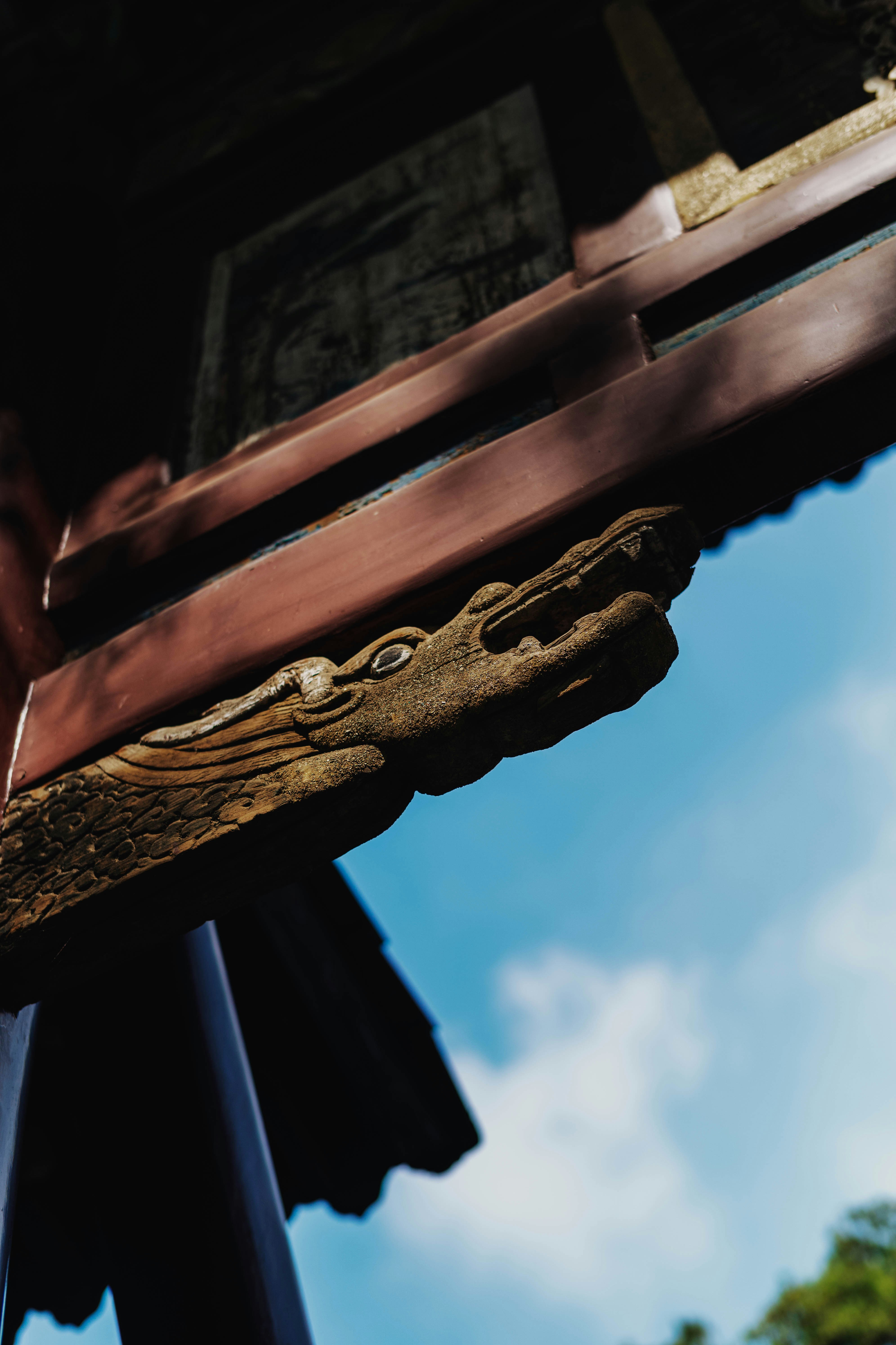 Dragon Carving Overlooking a Blue Sky at a Traditional Gate