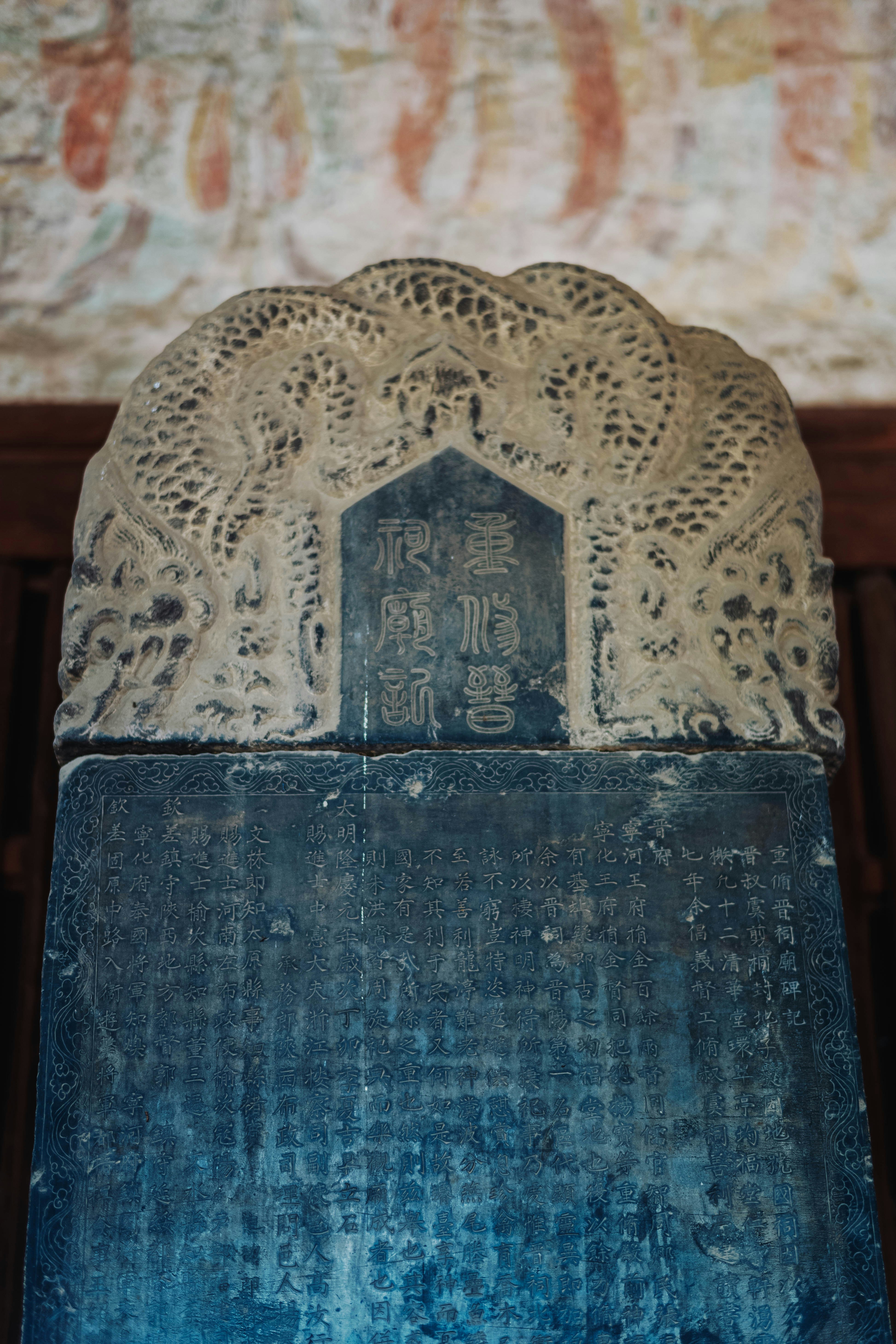 Stone Tablet Carved with Ancient Script Beneath Intricate Archway