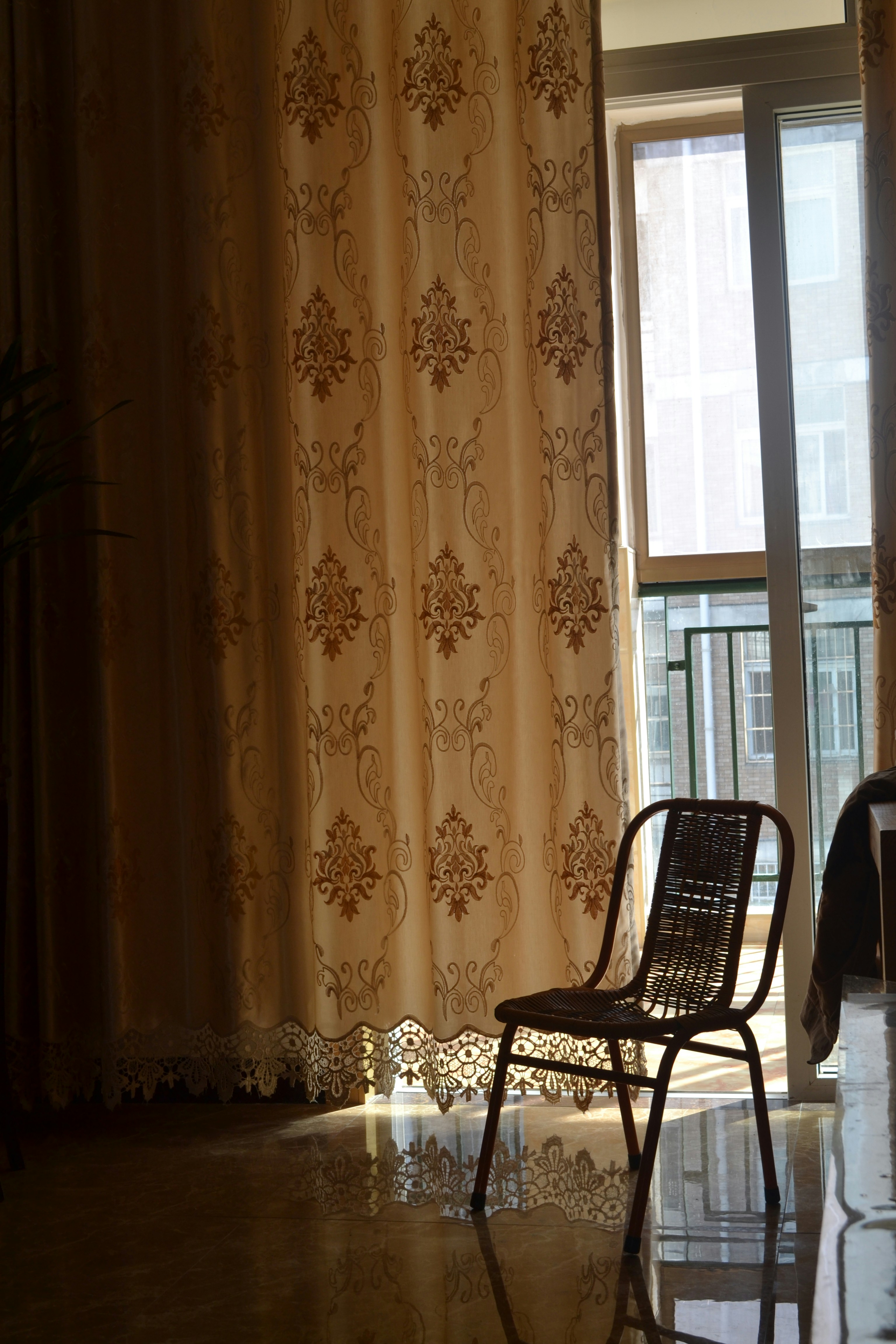Dusty Curtain Echoes: An Empty Balcony Scene with Sunlit Glass