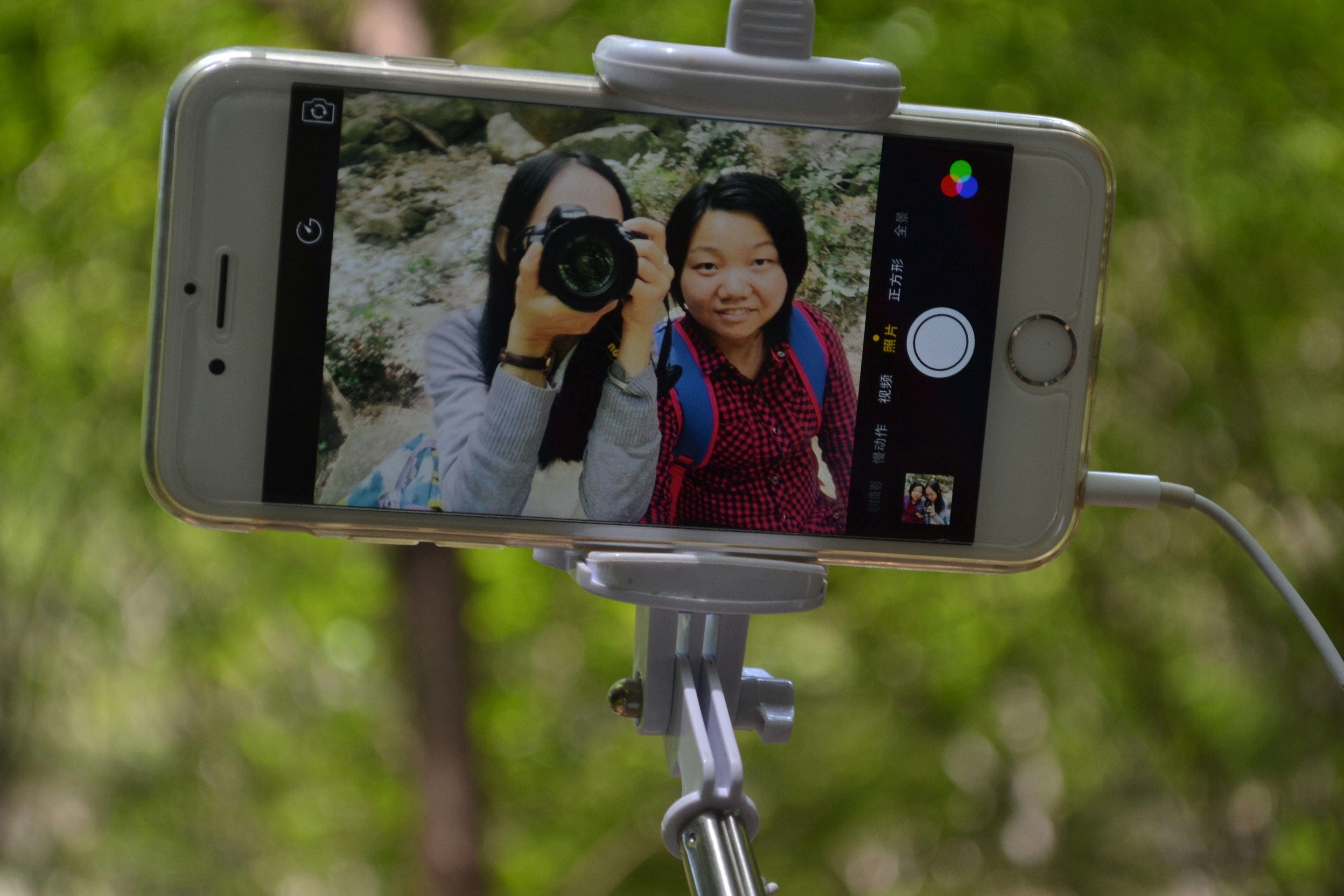 Two friends with a camera pose framed on a smartphone screen
