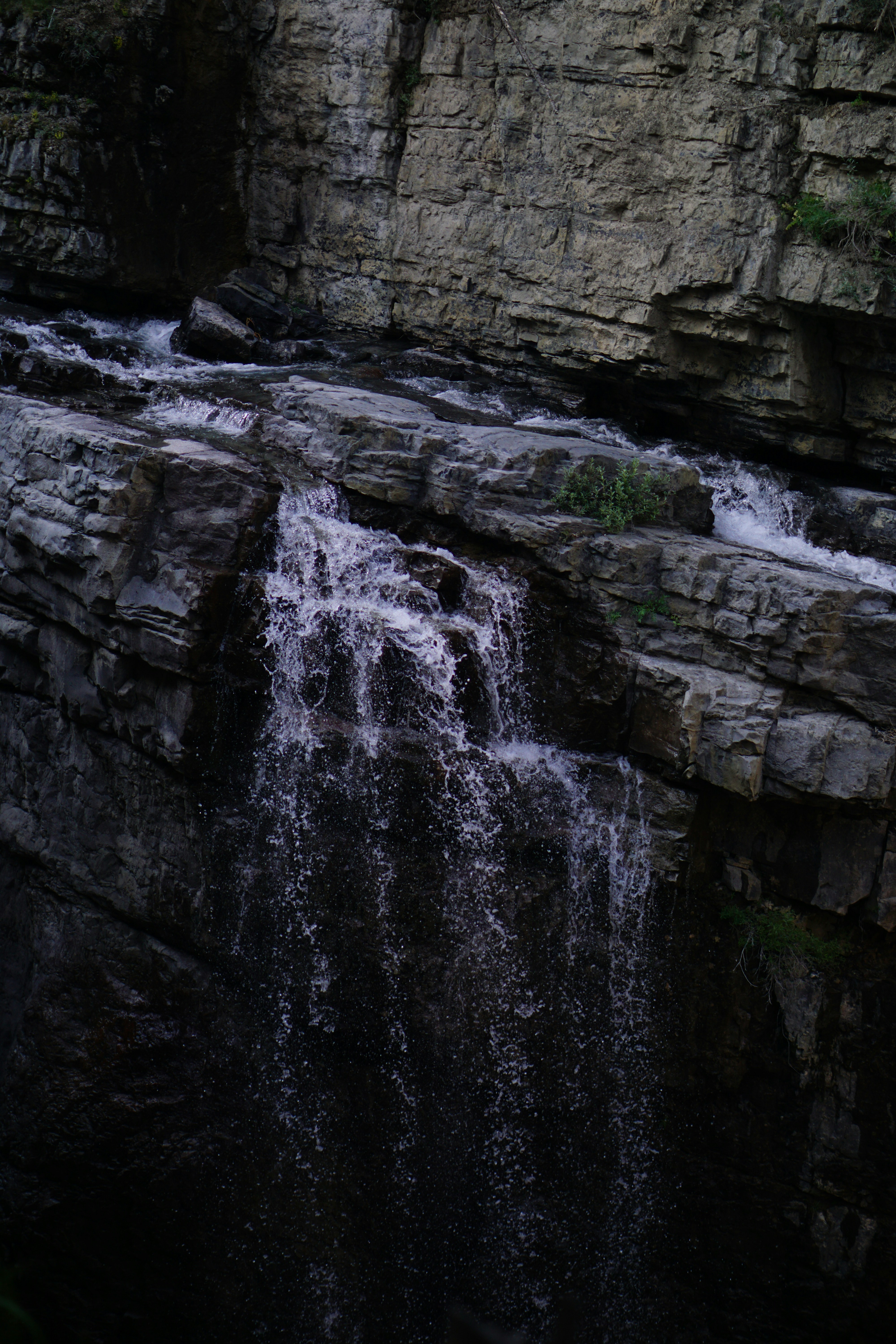 Shadowed Cascade: A Narrow Fall Between Weathered Cliffs