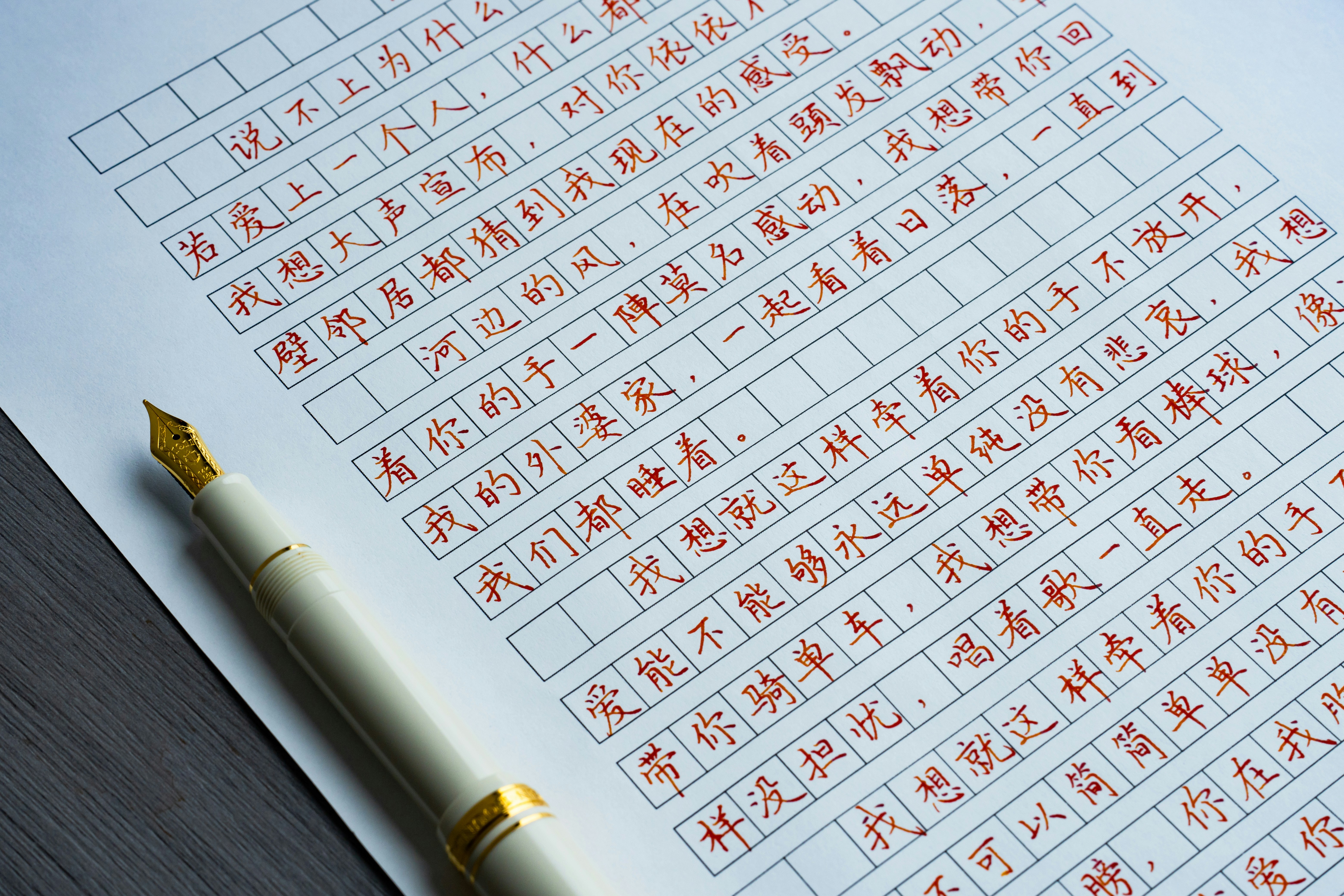 Red Ink Script on White Grid: A Delicate Practice Sheet with Gold-Nib Pen