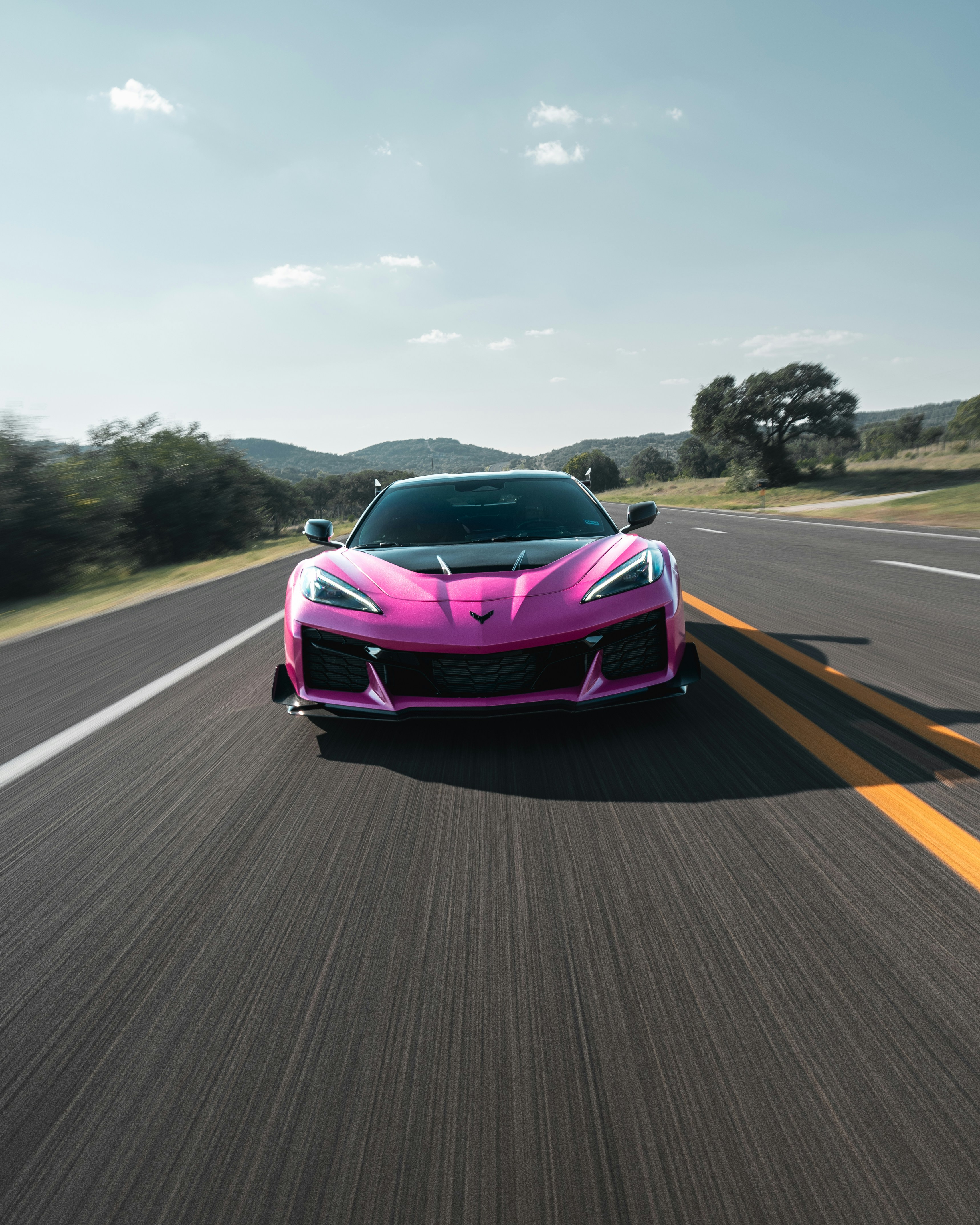 Scarlet Streak: A Pink Corvette Charging Down an Open Highway