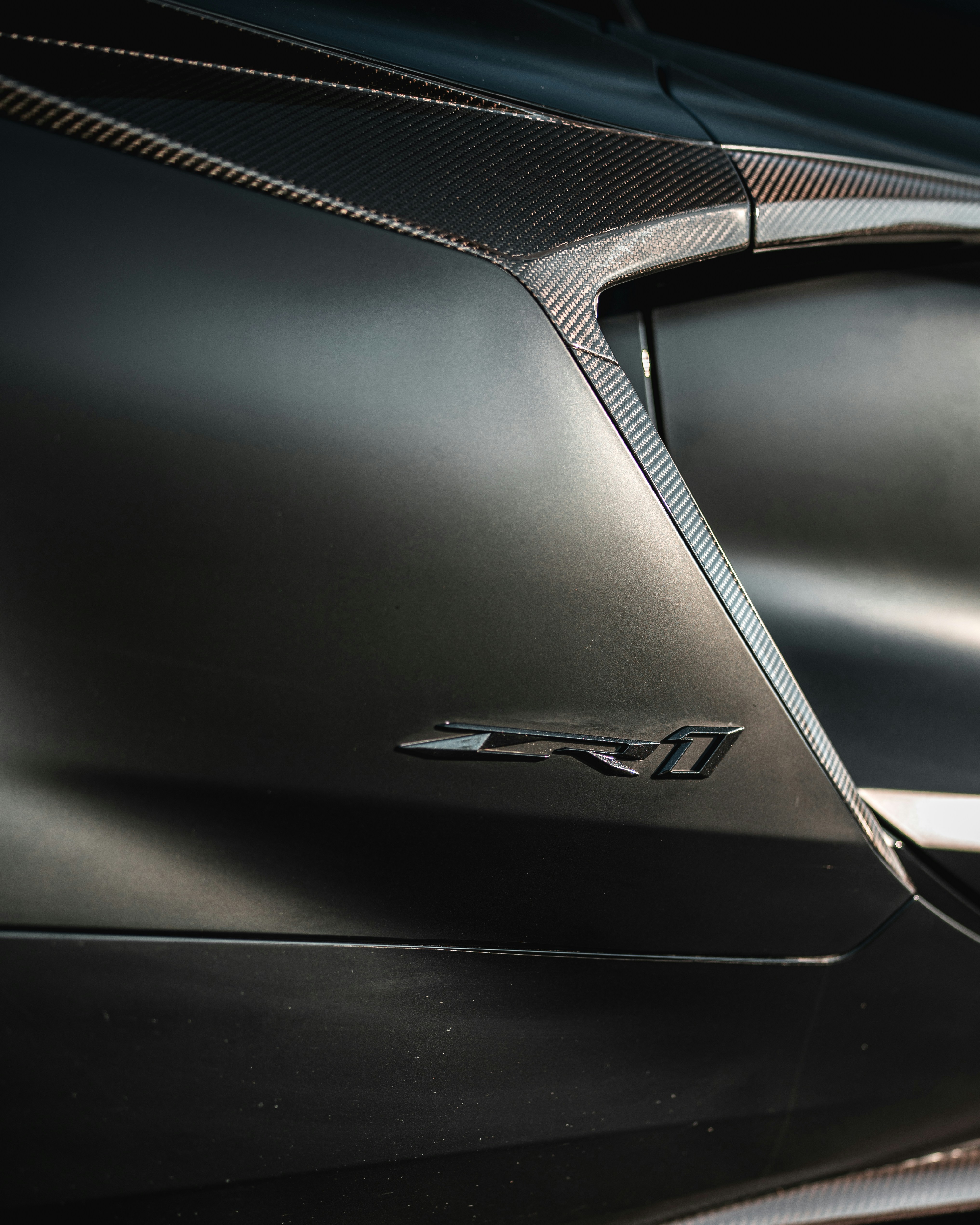 Carbon weave and badge: close-up of a sports car tail with XR cooled panel