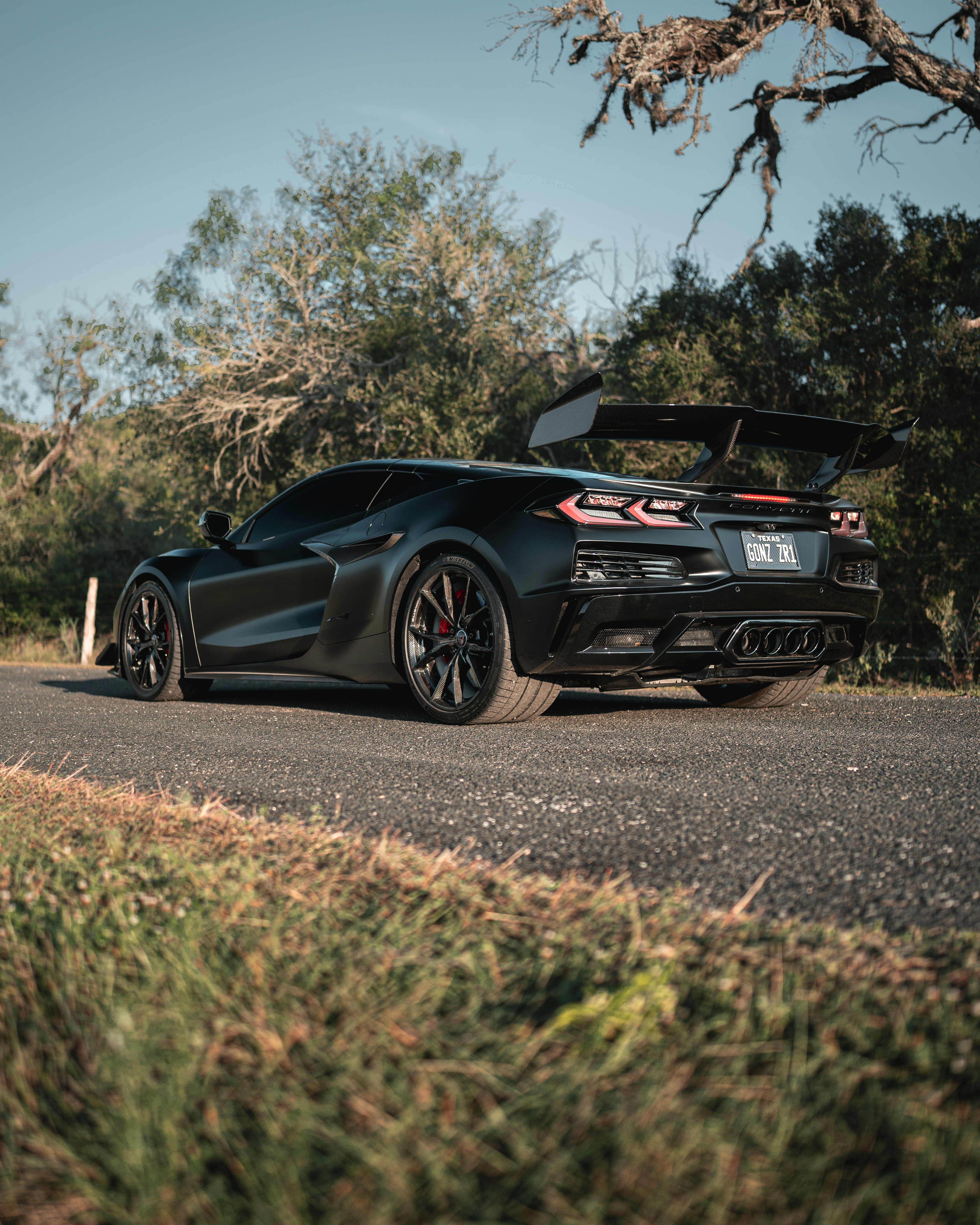 Dark Deluge of Power: A Ford-braced Corvette? (Note: descriptive focusing on the visible car with rear spoiler and wide stance)