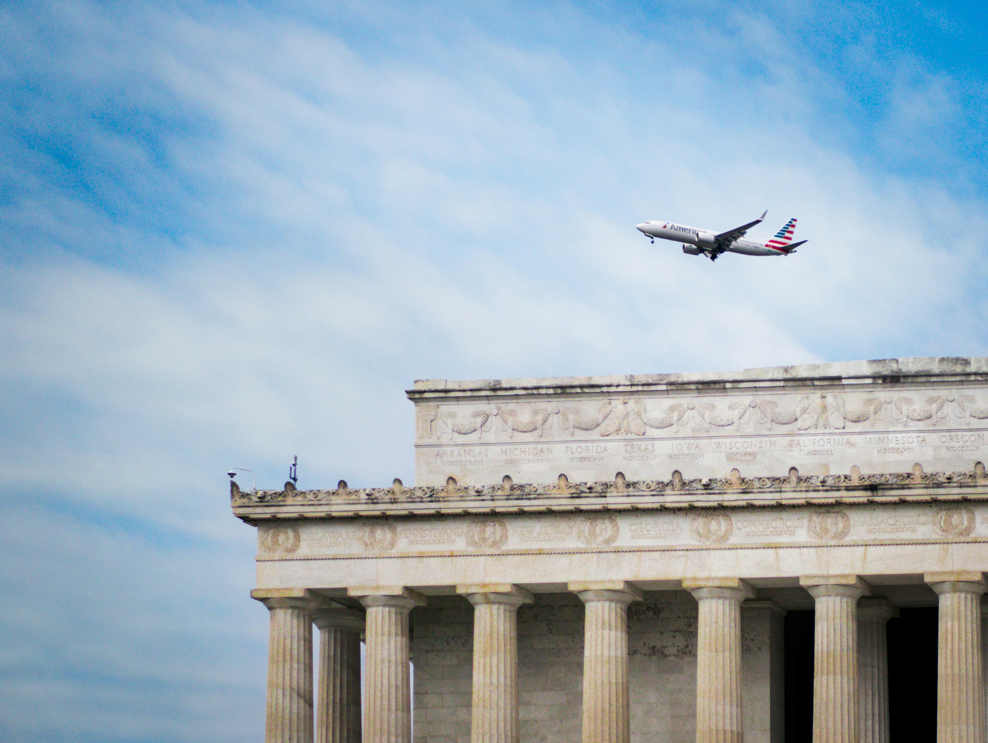 Airliner over the Pediment: A Moment of Modern Silence Above an Ancient Frieze