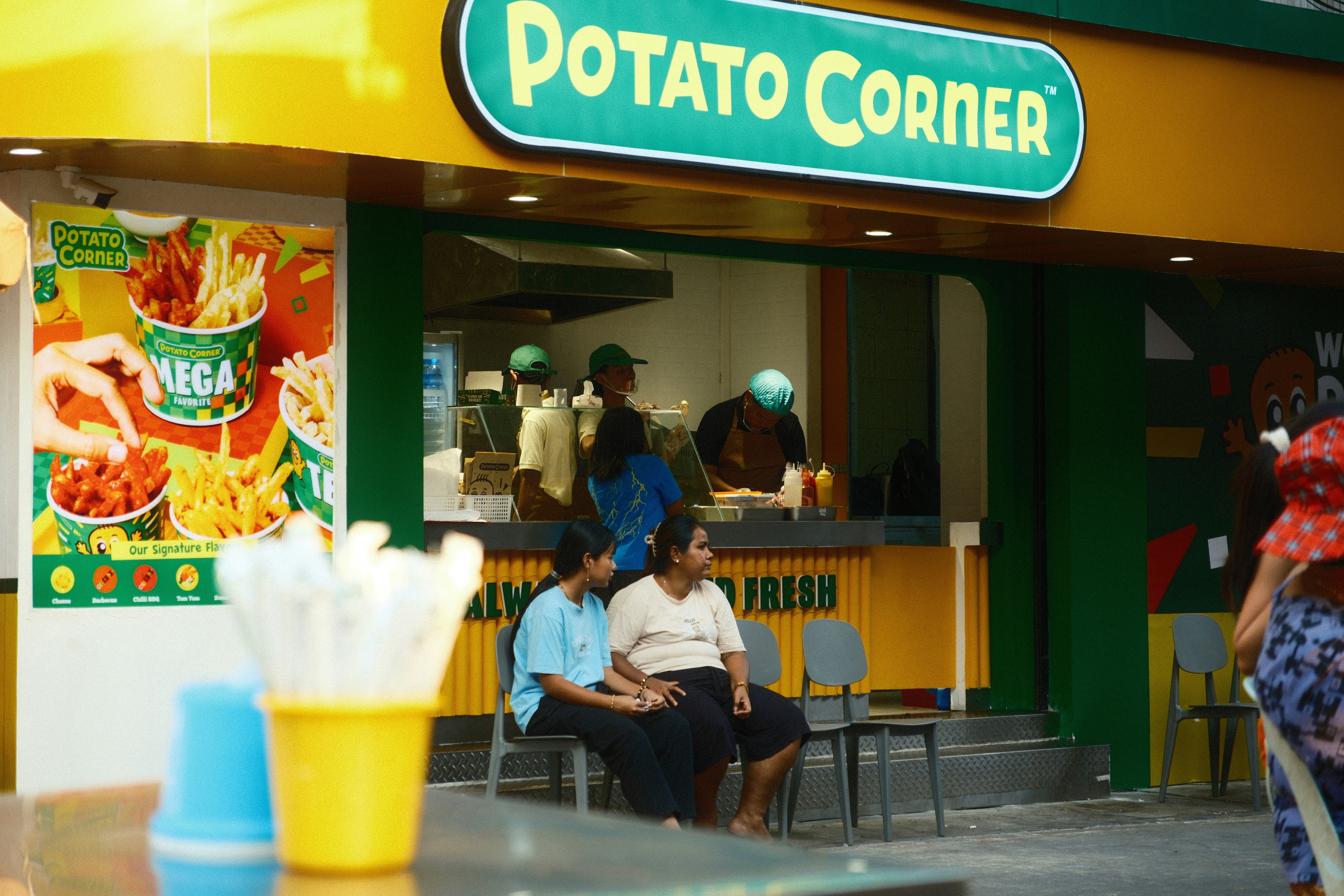 Cafe Window Echoes: People Waiting at Potato Corner