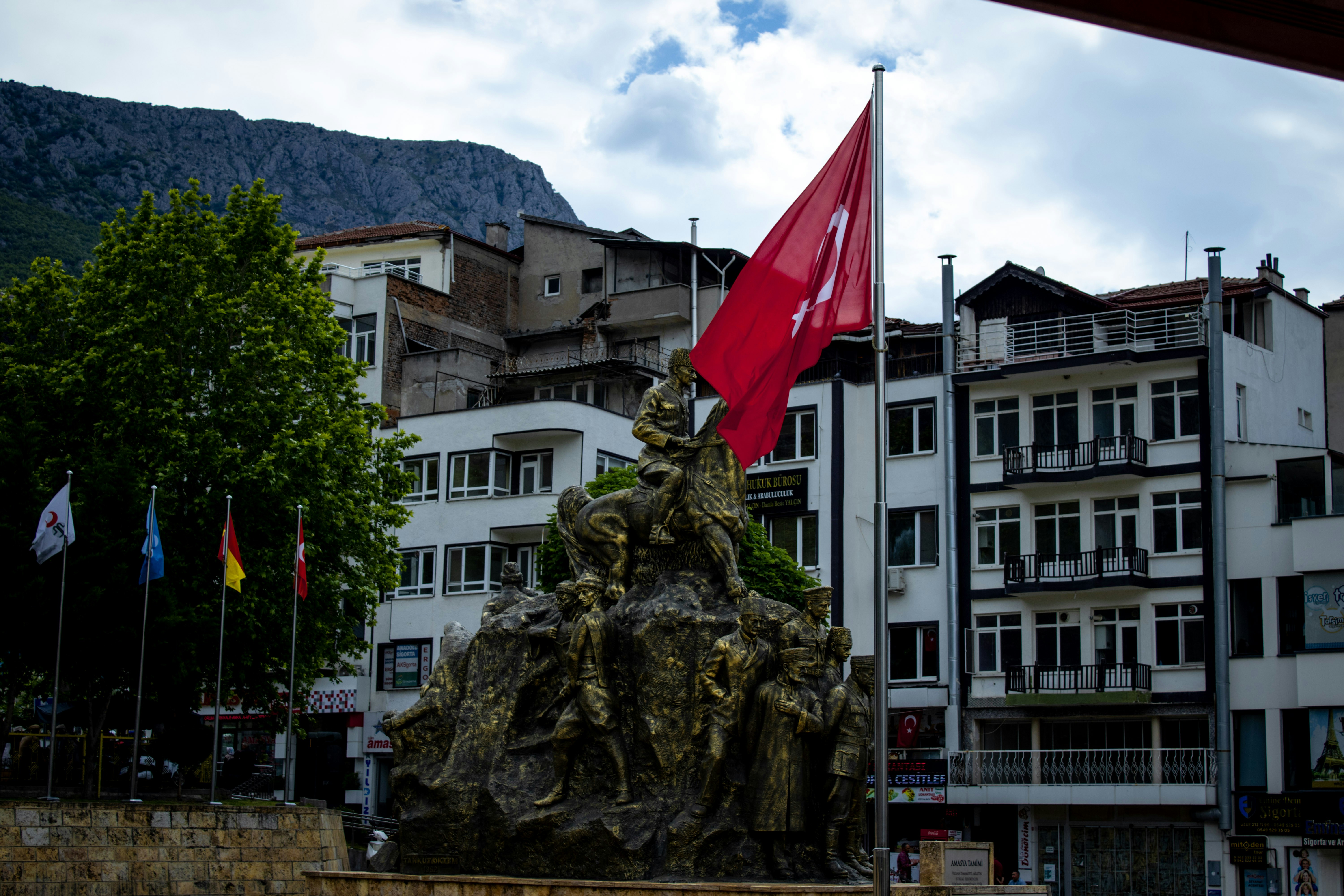 Flag over the heroic sculpture in a sunlit town square