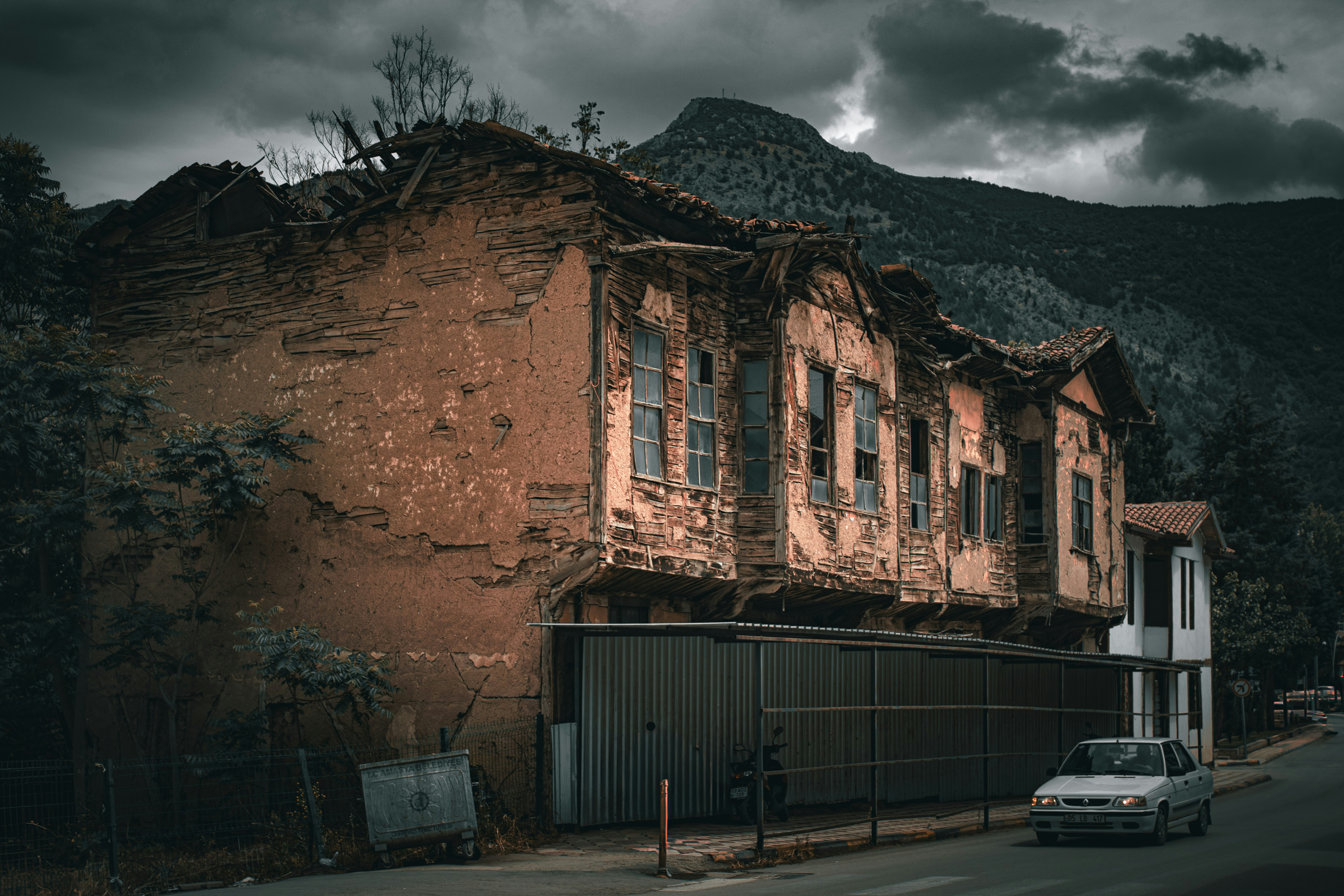 Ruins by the Roadside: An abandoned brick facade under looming clouds