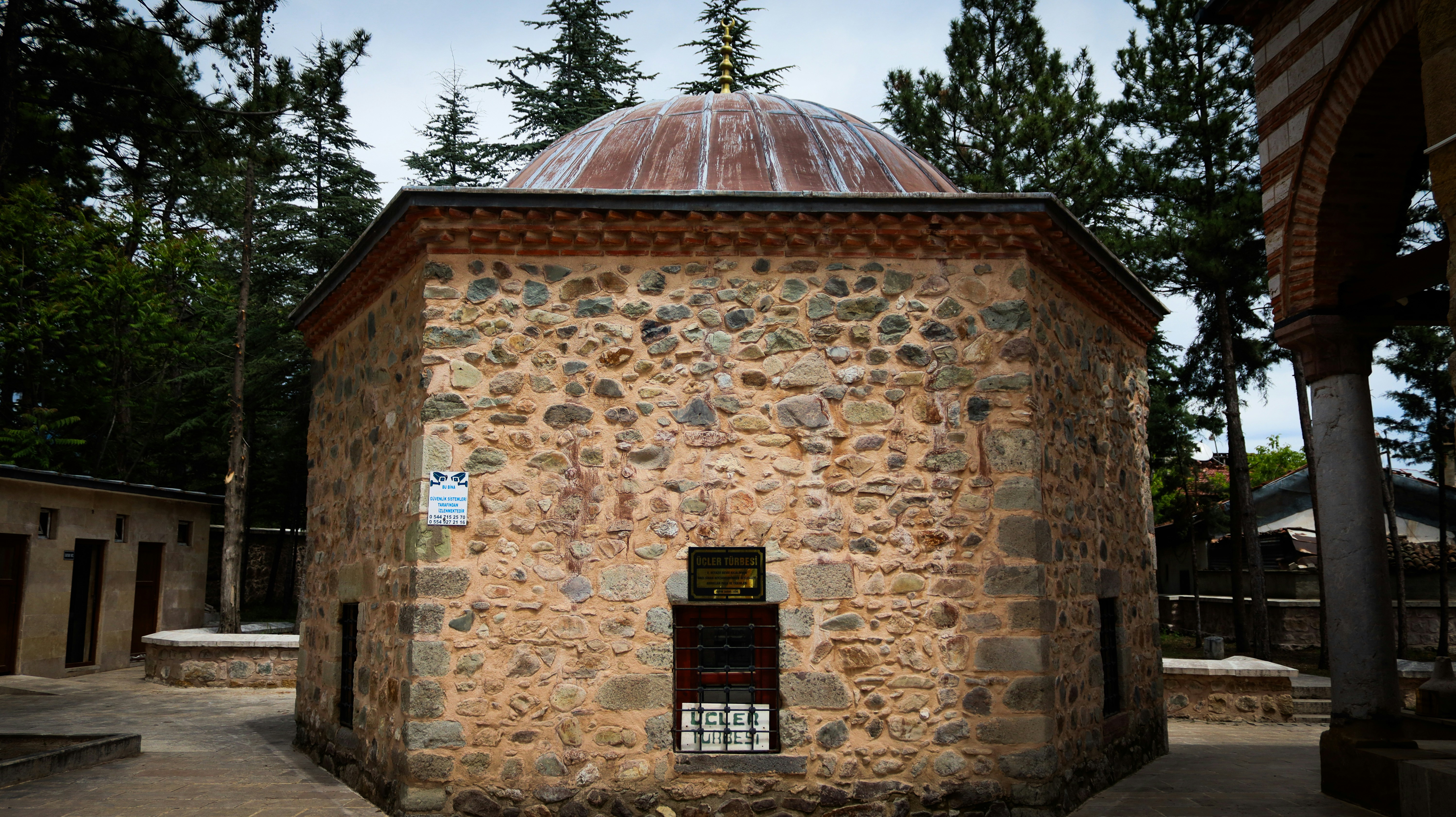 Stone Chapel Under a Rusty Dome Framed by Forest Awnings