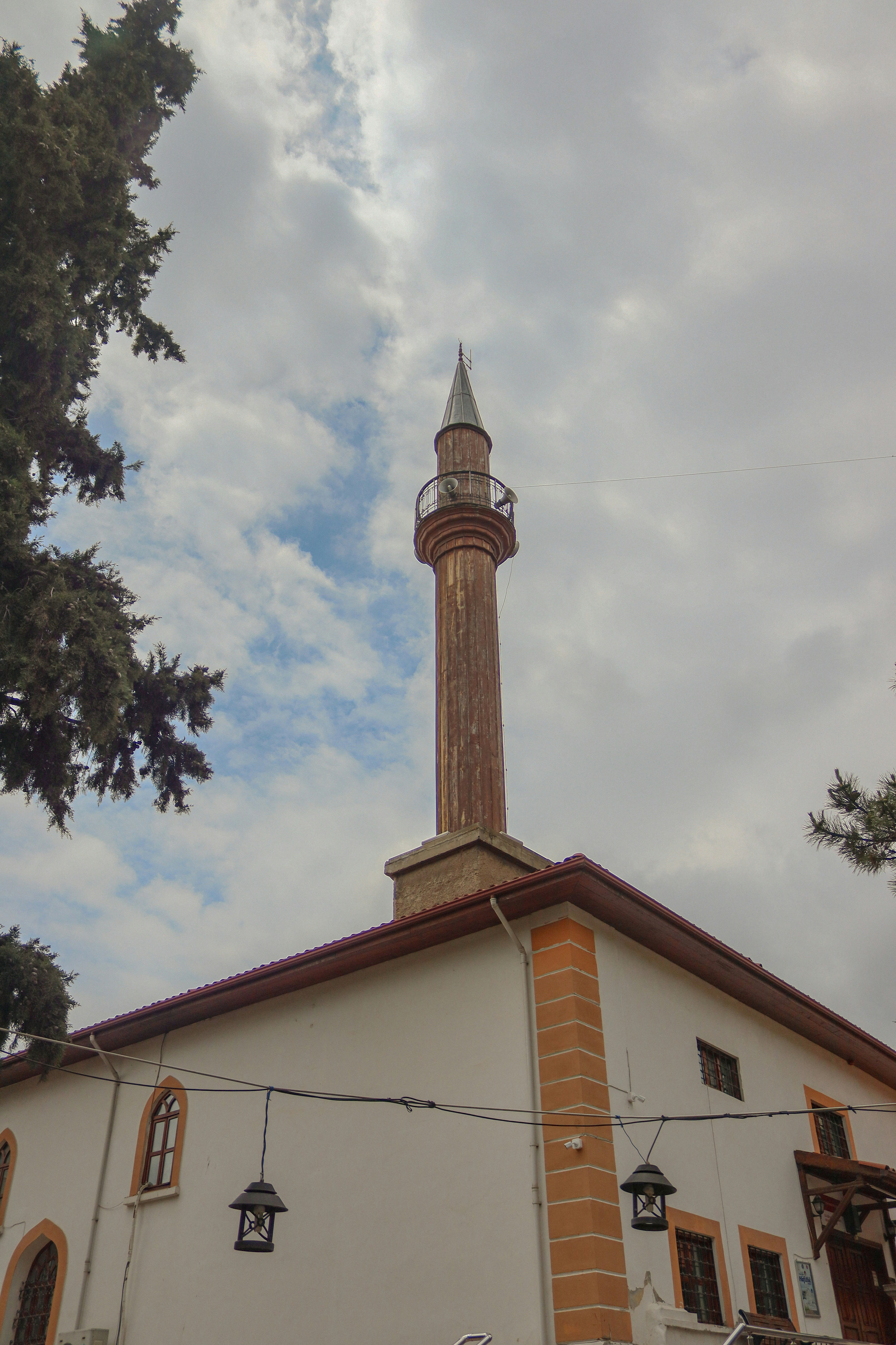 Minaret Rising Over a School Building Under Cheery Clouds
