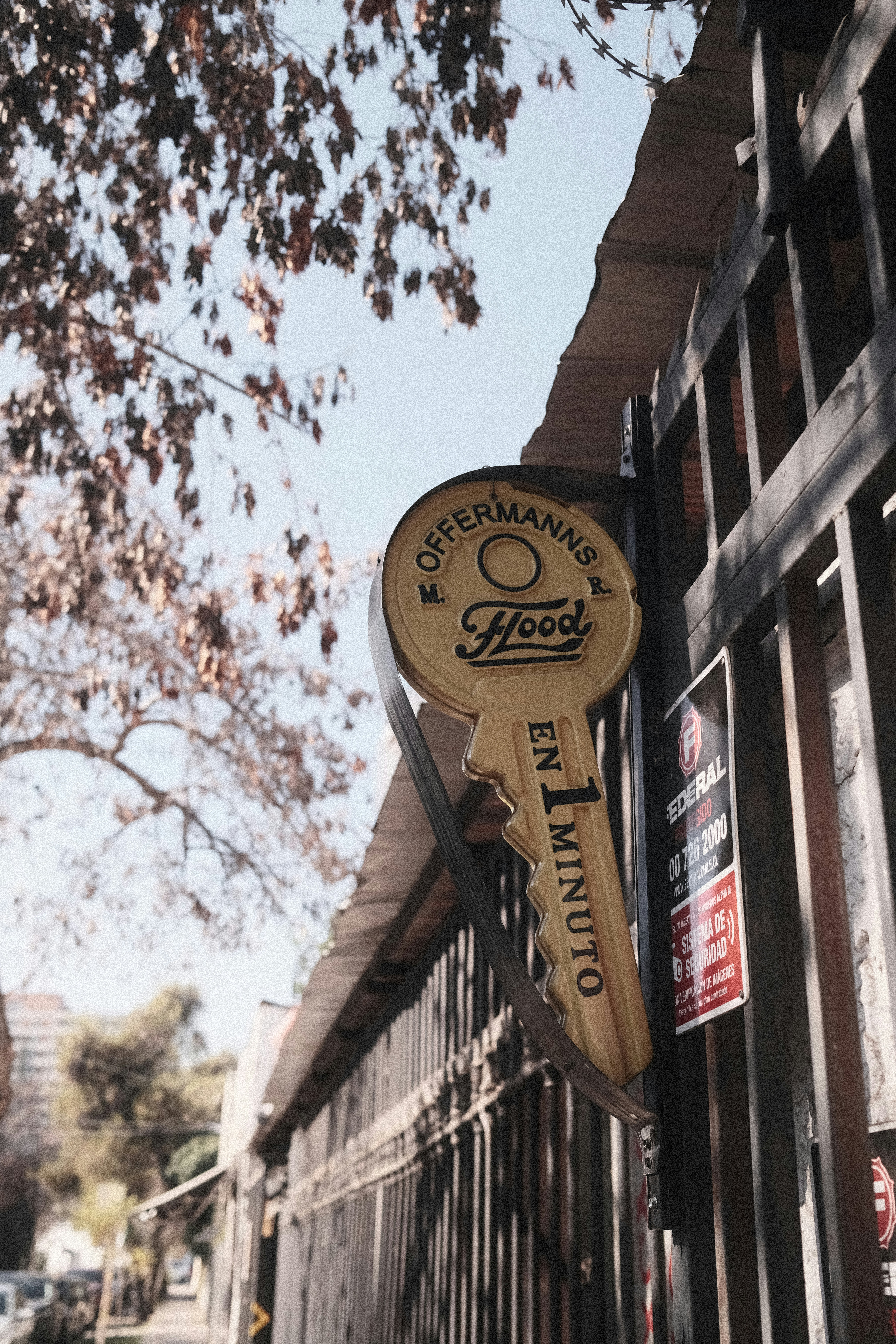 Neon Pedestal: A Vintage Sign Adrift on a Sunlit Street