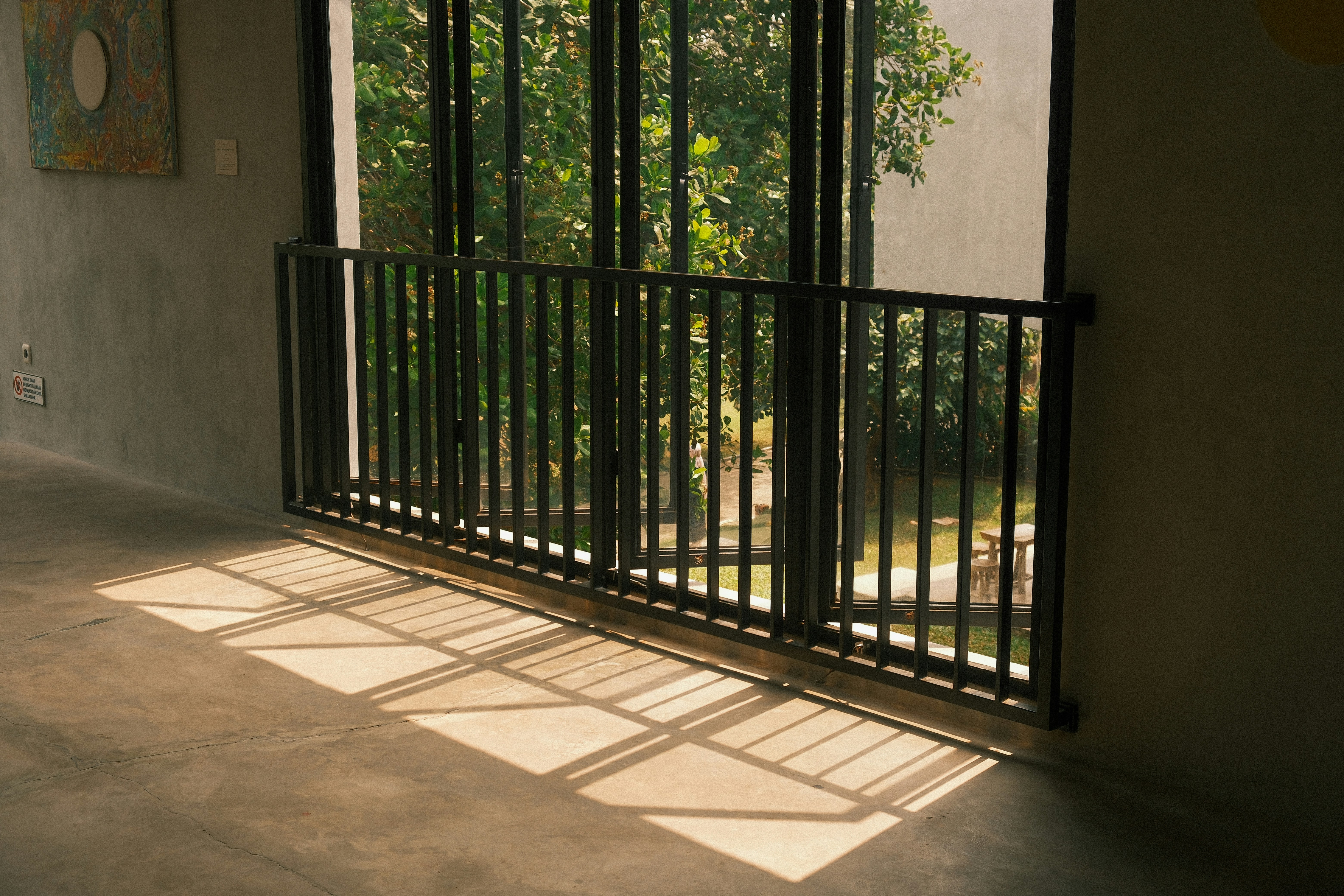 Sunlit Balcony Railing Cast Shadows Across Empty Room