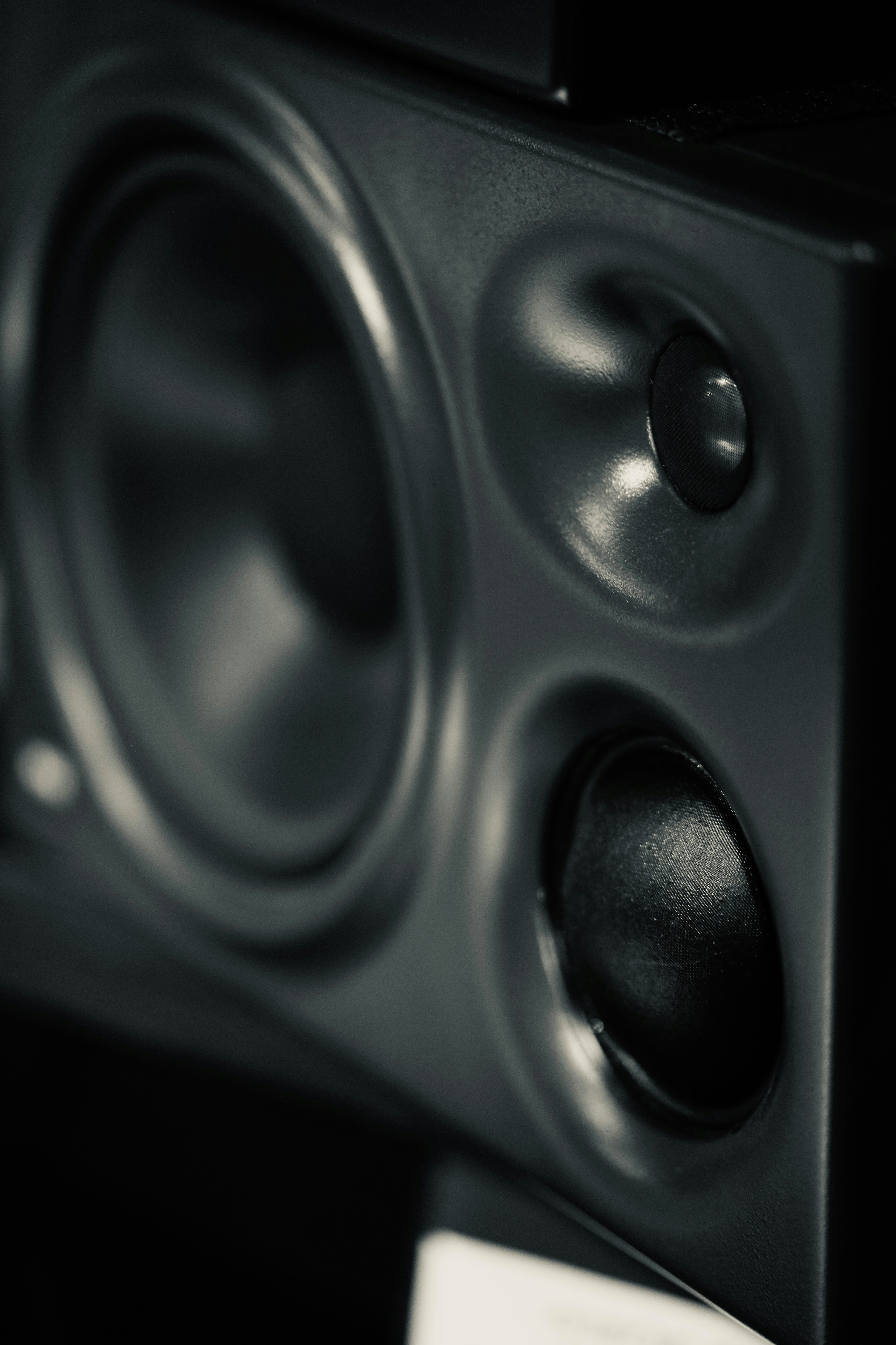 Monolithic Speaker Portrait: Close-Up of Dome Tweeters in Shadowed Corner