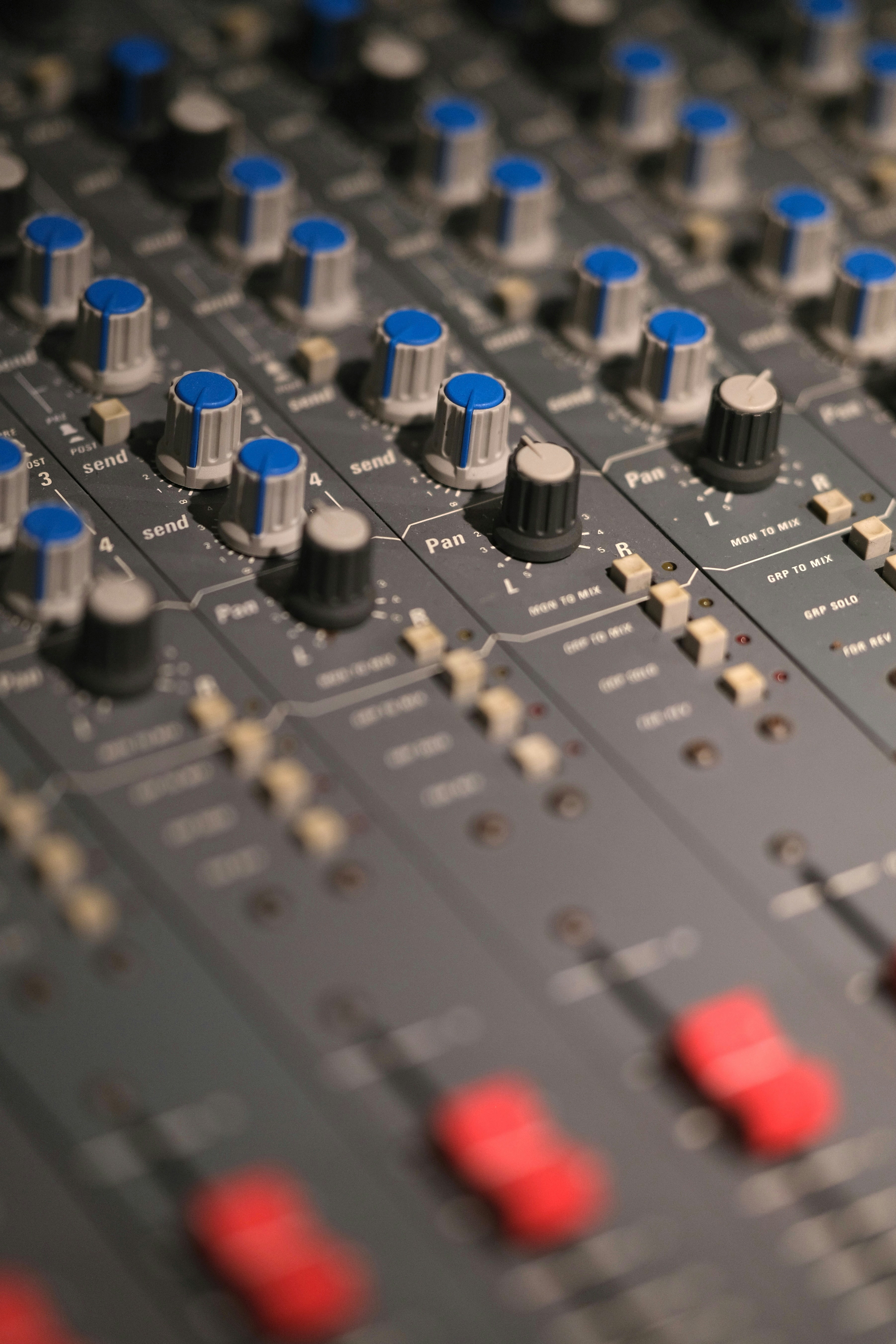 Blue-topped Knobs and Red Faders: A Close-Up on a Studio Mix Console