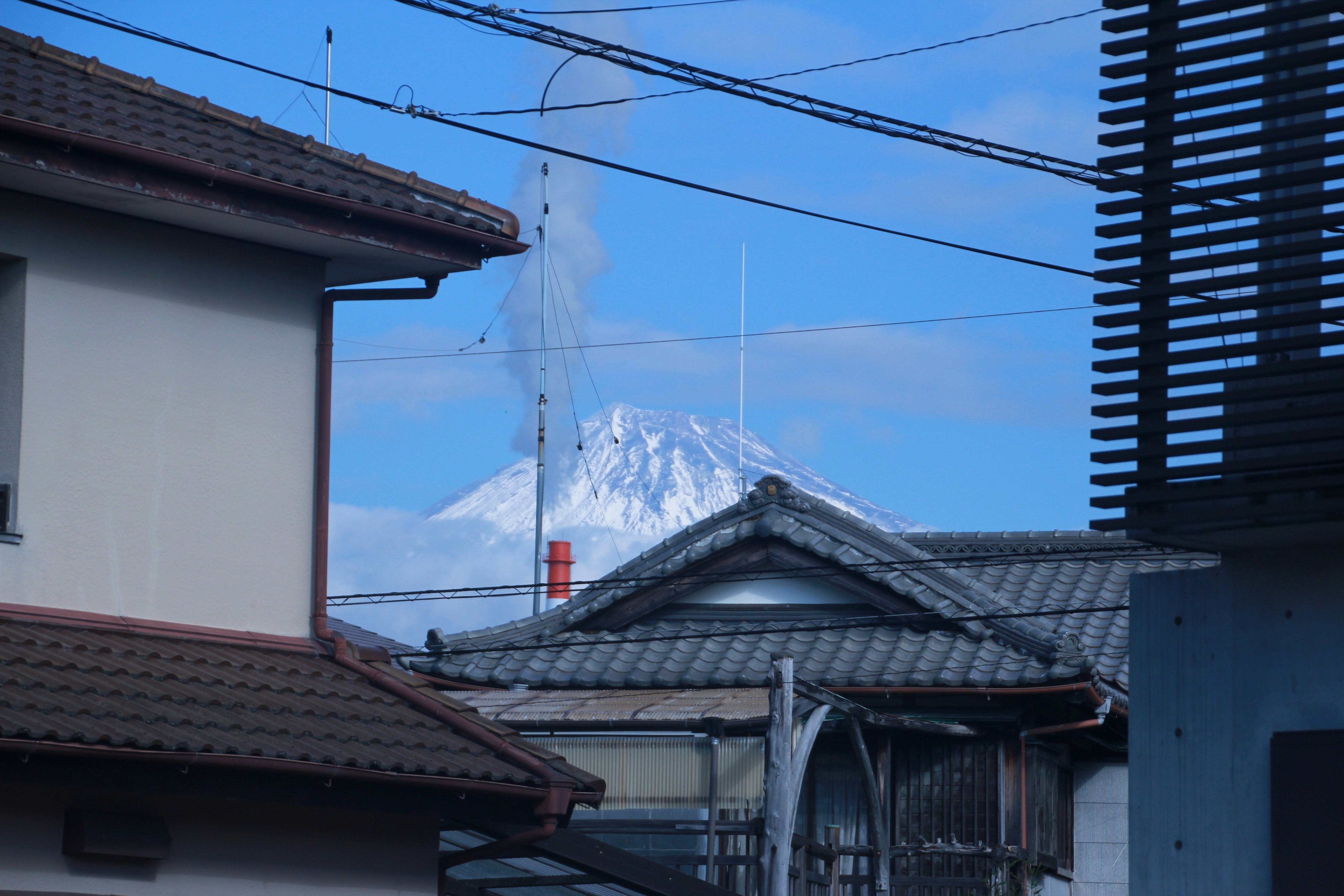 Snow-capped Peak Peeking Above Urban Rooflines