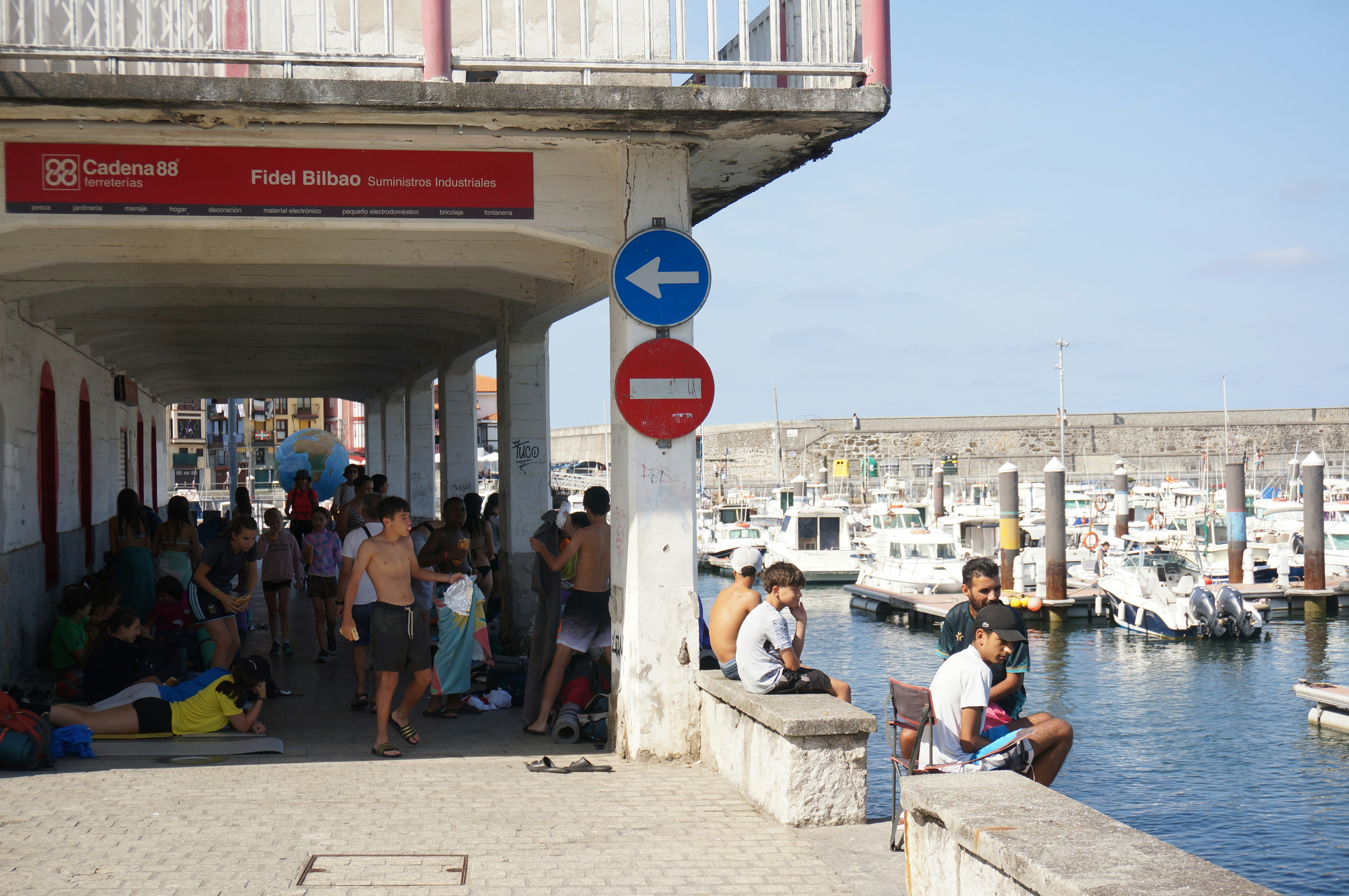 Bathed in Harbor Light: People, Boats, and a Quiet Walkway