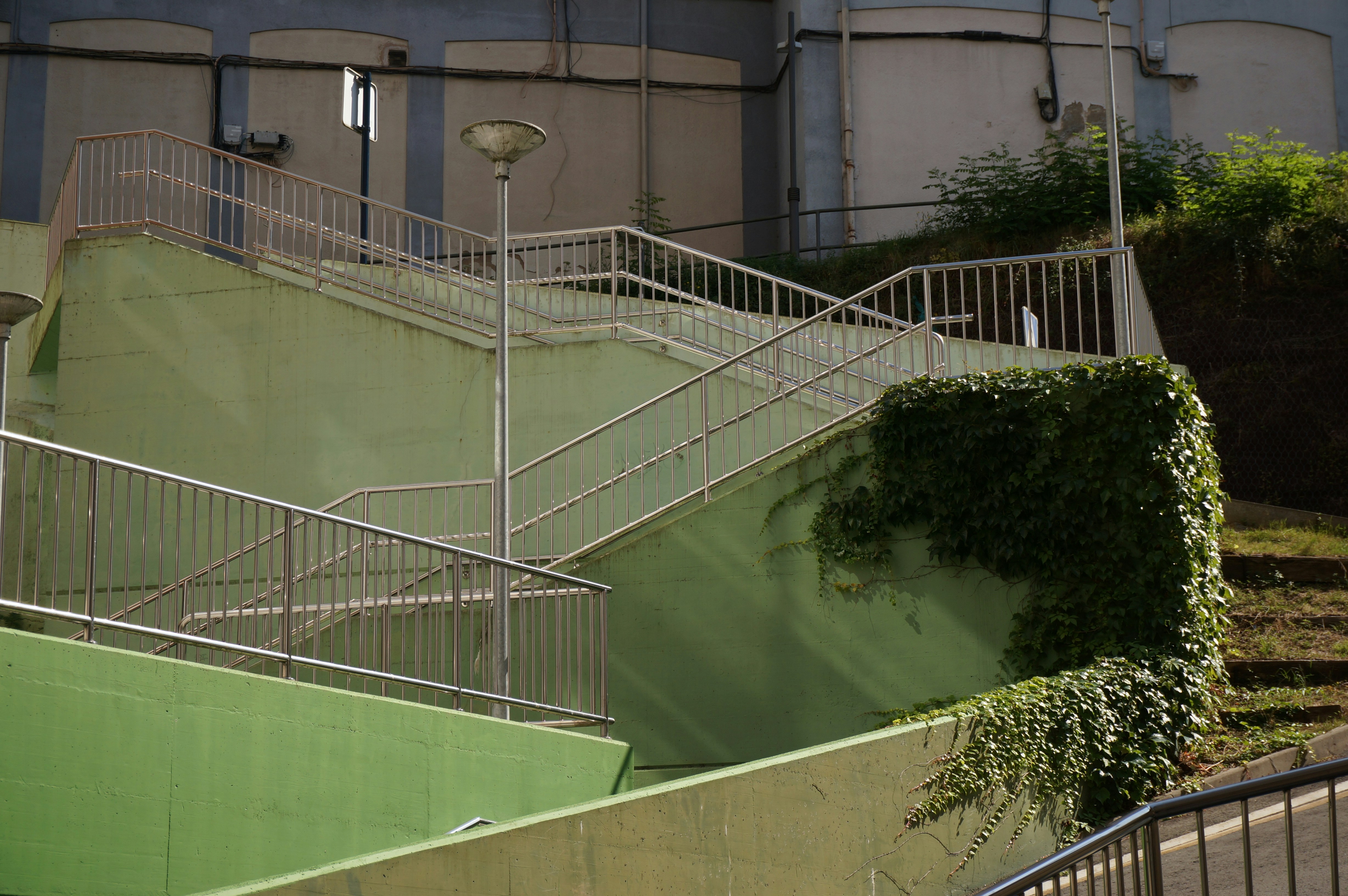 Green Terraces and Metal Railings Lead the Eye Up a Retrofit Staircase
