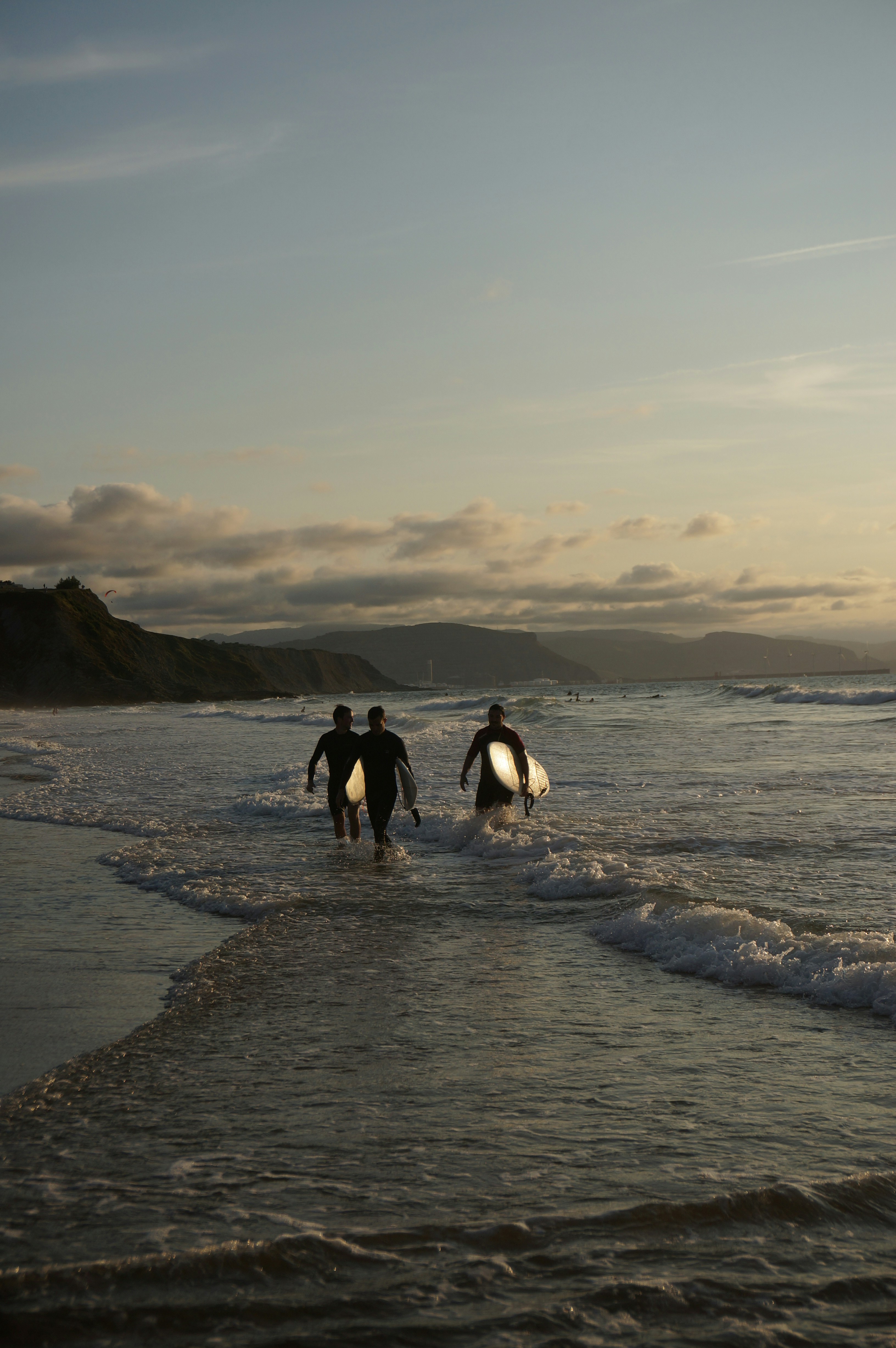 Sunset Run: Surfers Return to Shore at Dusk