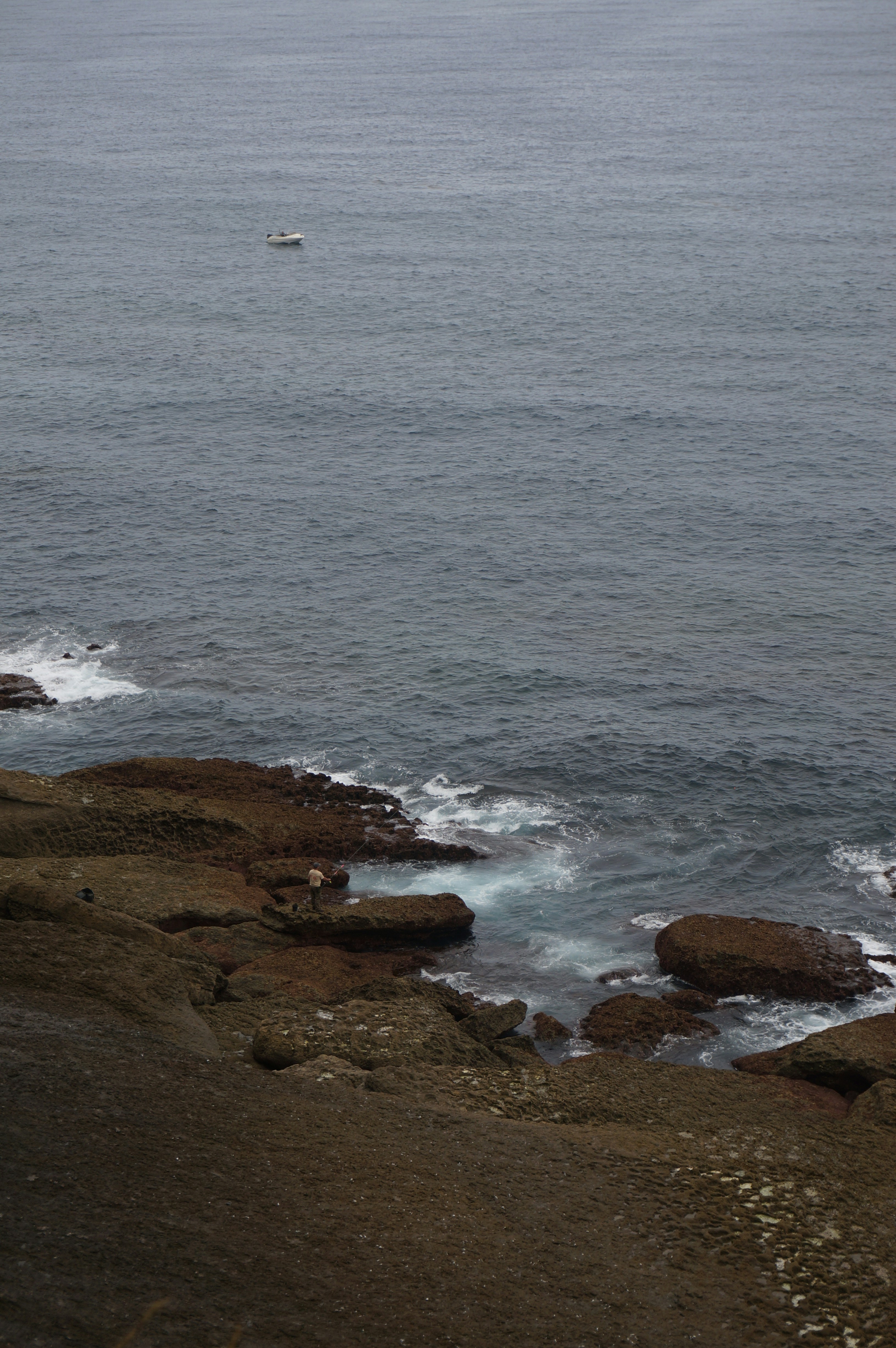 Low Tide, Quiet Boat, and Weathered Cliffs