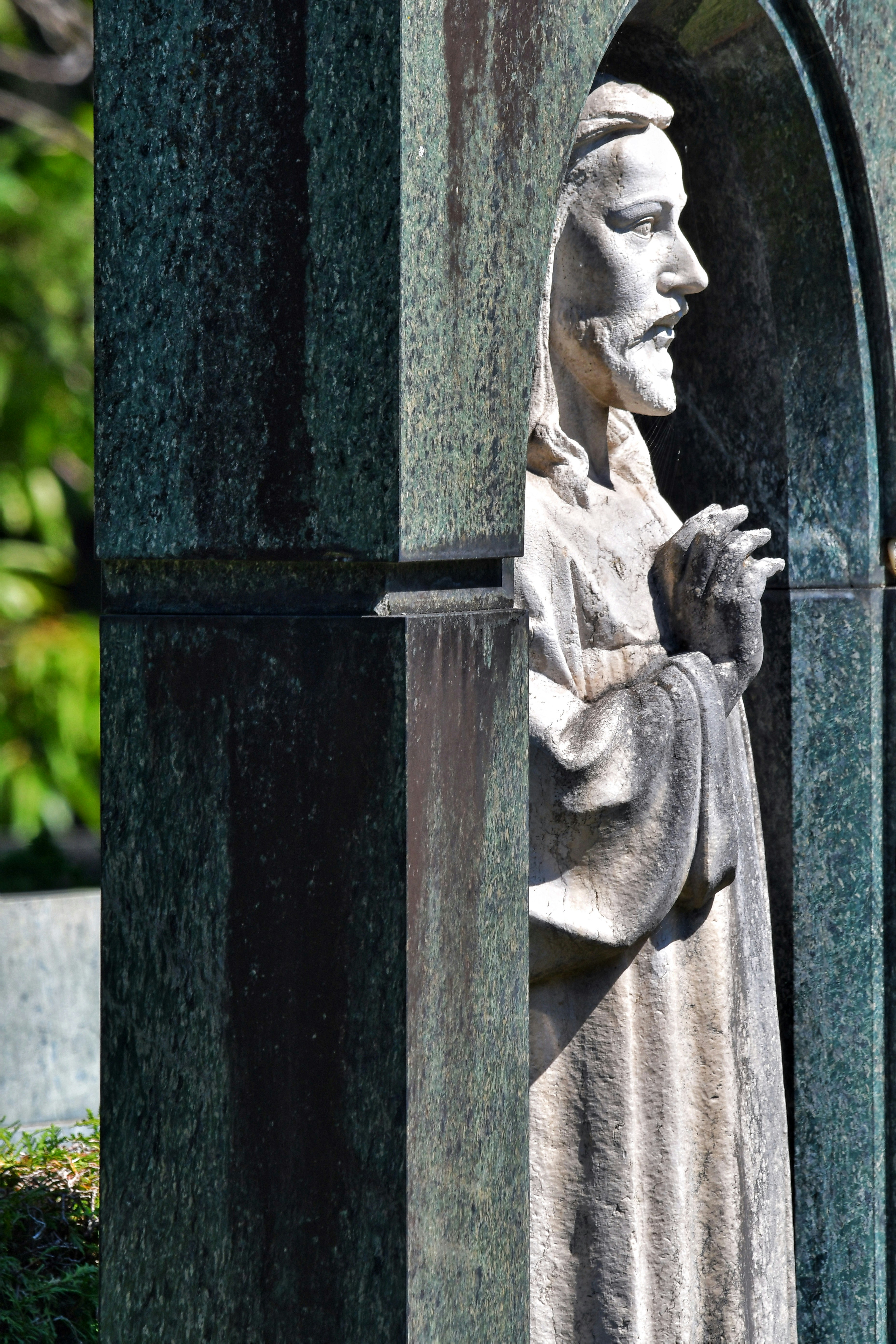 Quiet Reverence: carved figure peeking through stone arch