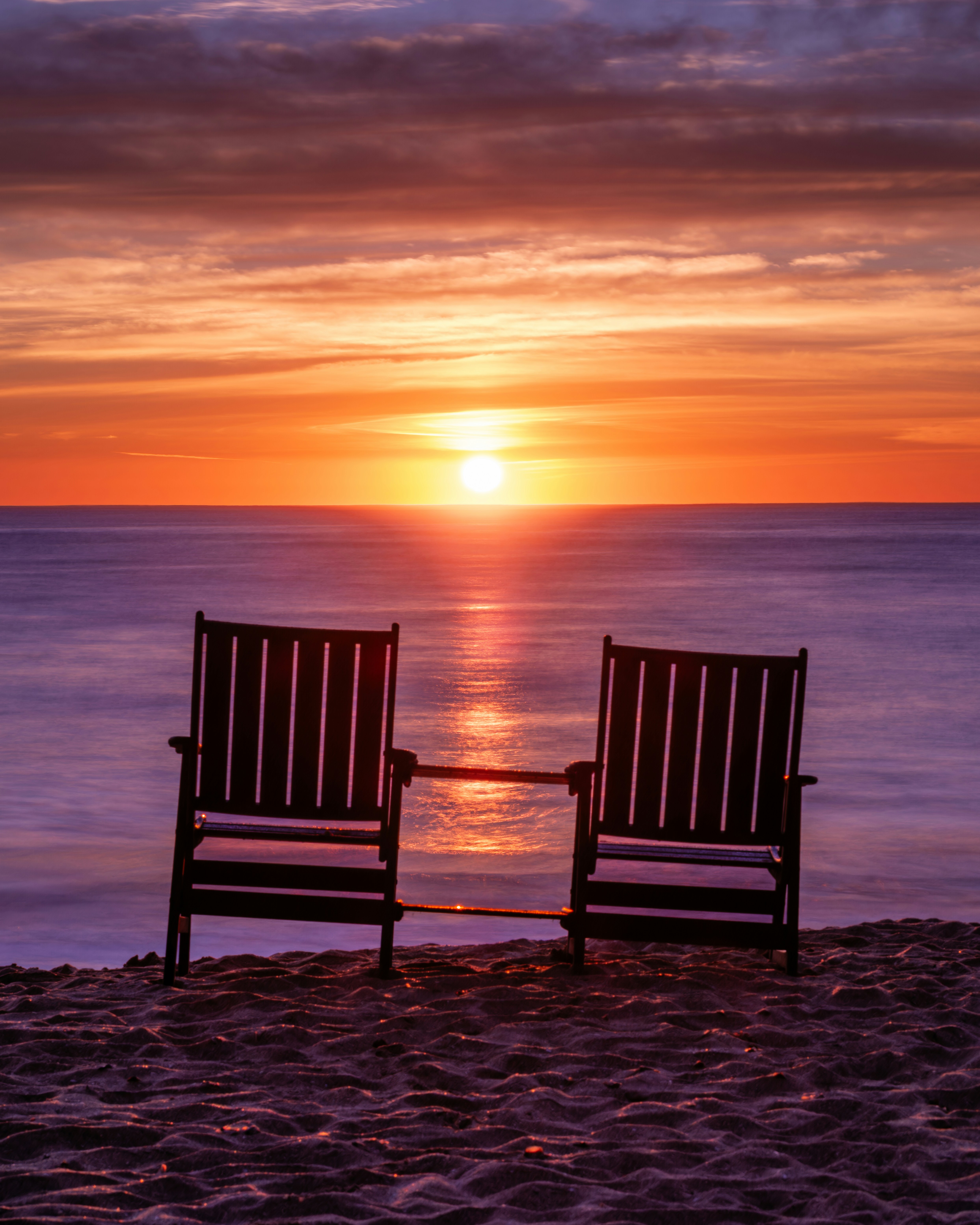 Two Silent Chairs at Sunset Over Calm Seas