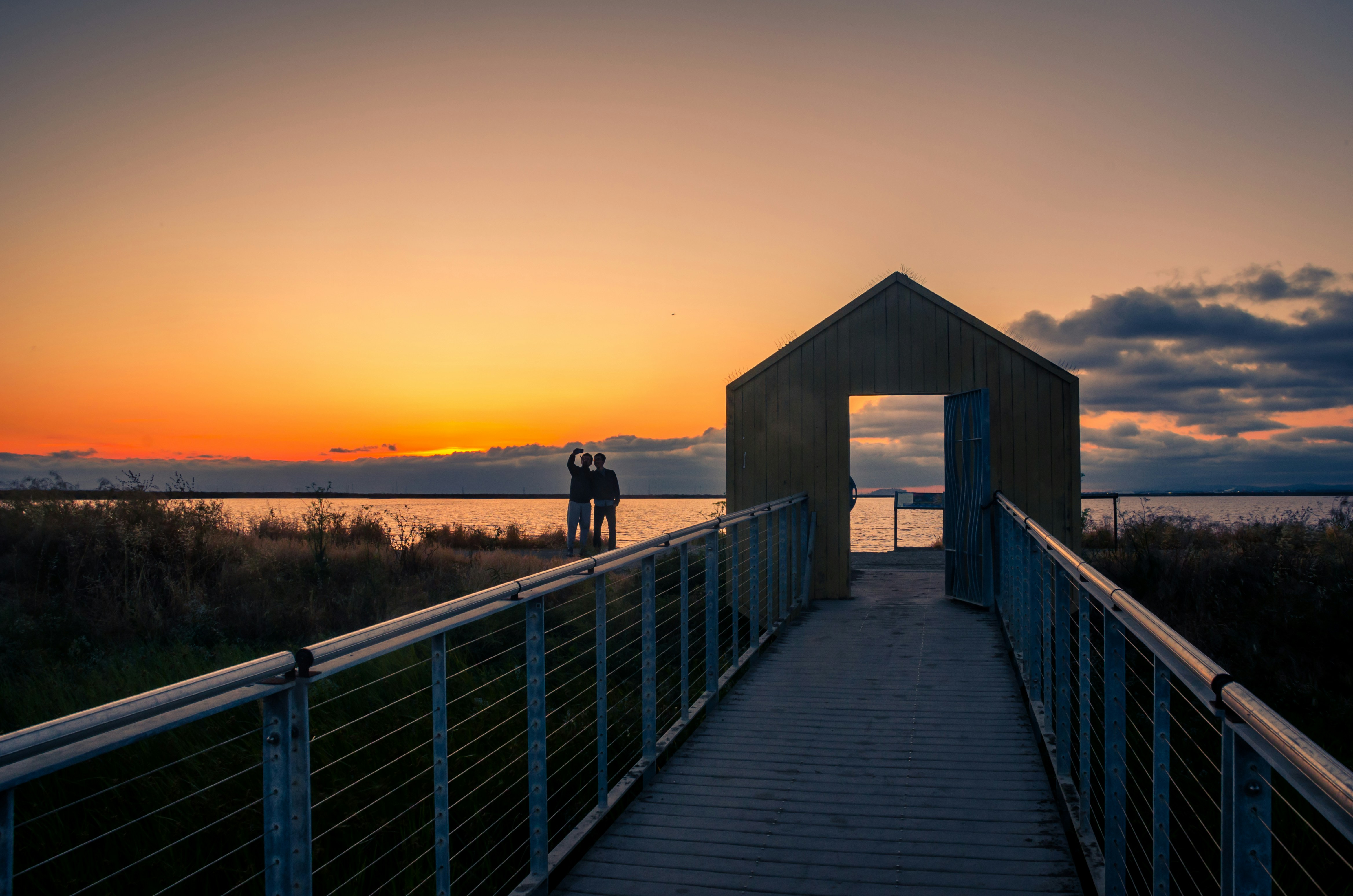 Sunset Couple on a Pier: A Silent Meet at the Edge